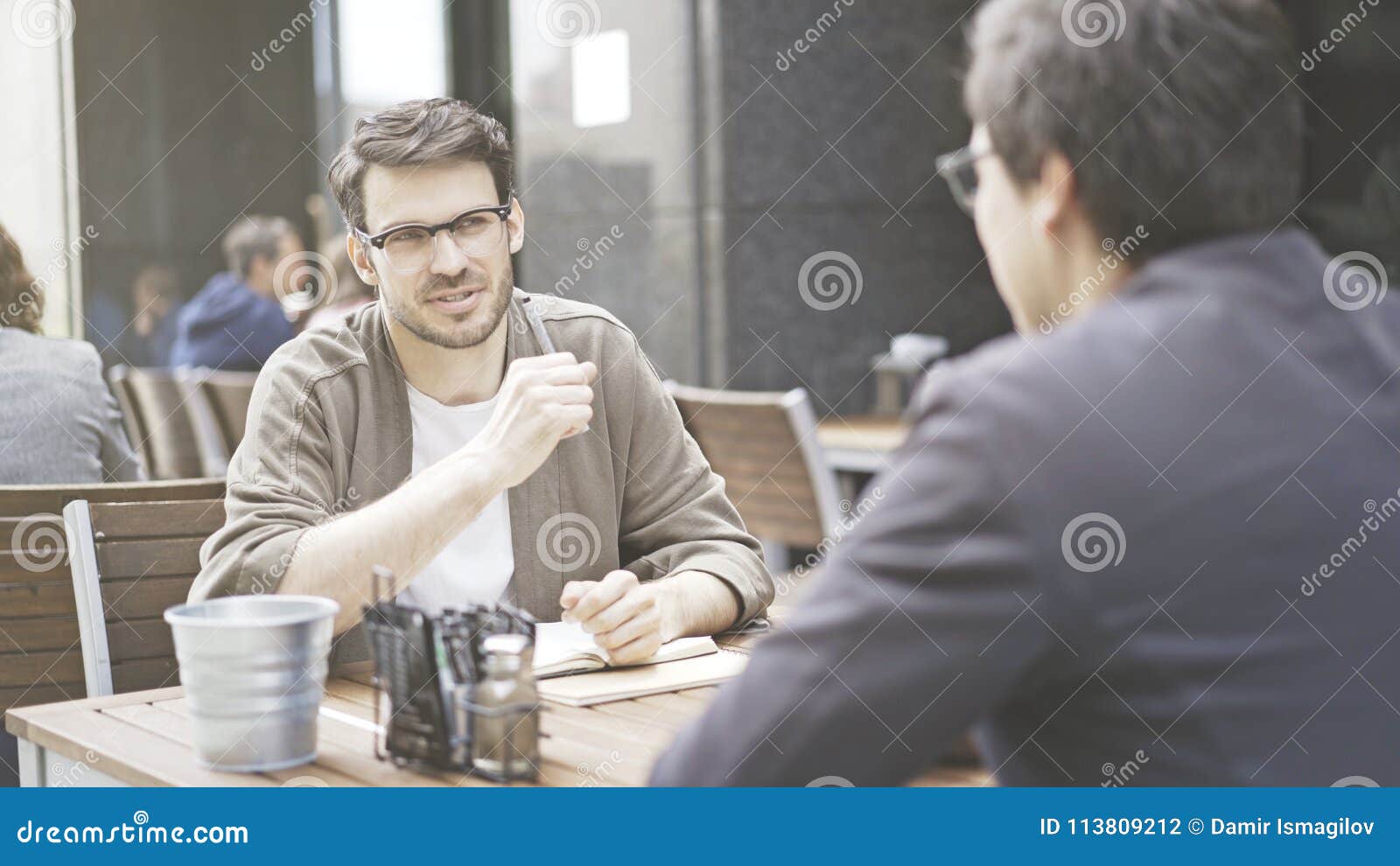 Two Friends are Talking at Table of the Cafe Outdoors Stock Photo ...