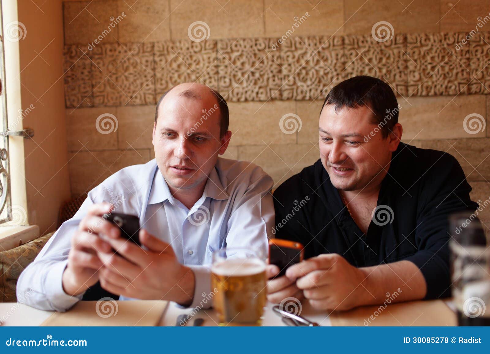 Two Friends Using Mobile Phones Stock Photo - Image of shoulders, brown ...