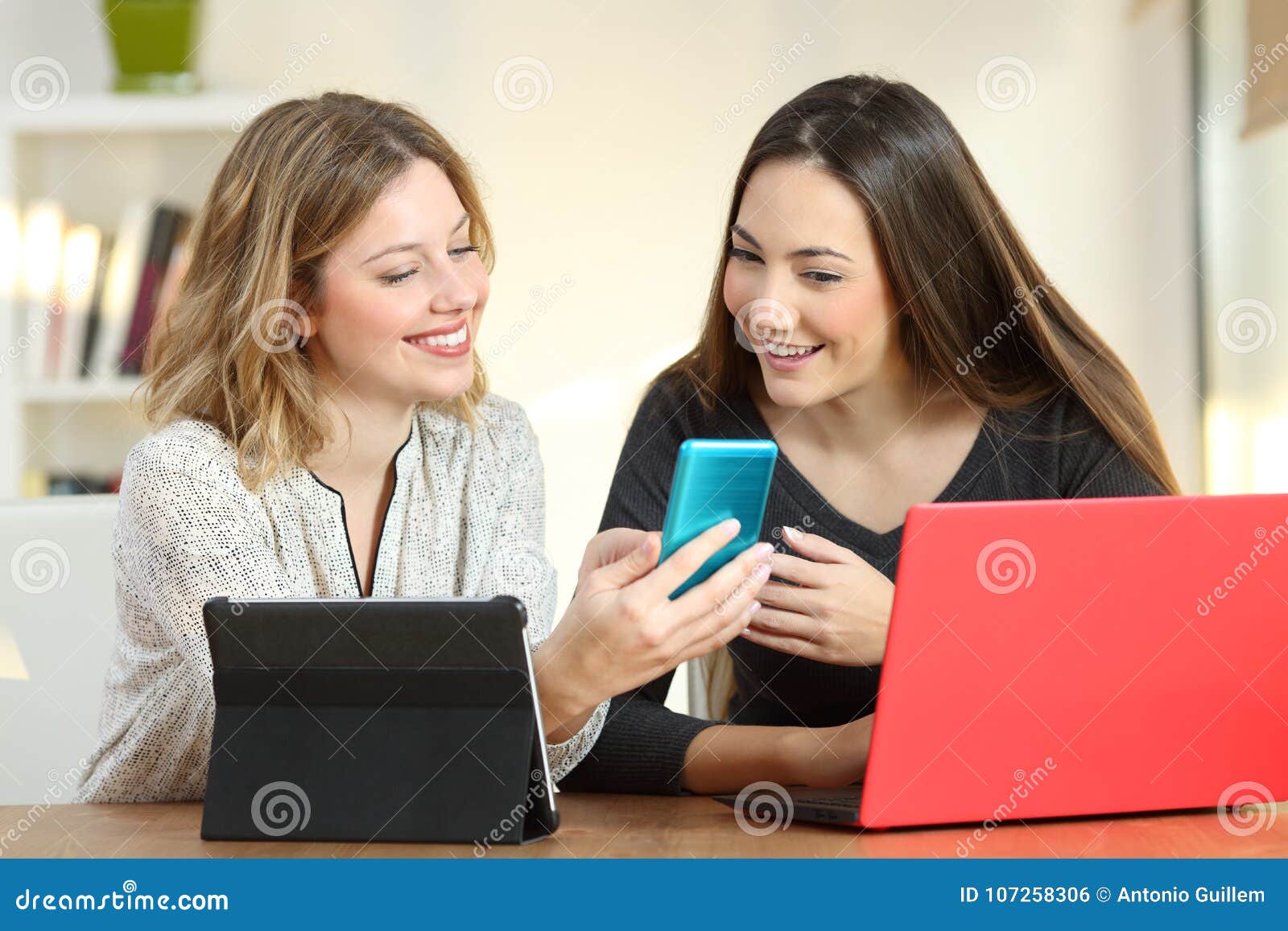 Two Friends Using Multiple Devices at Home Stock Photo - Image of ...