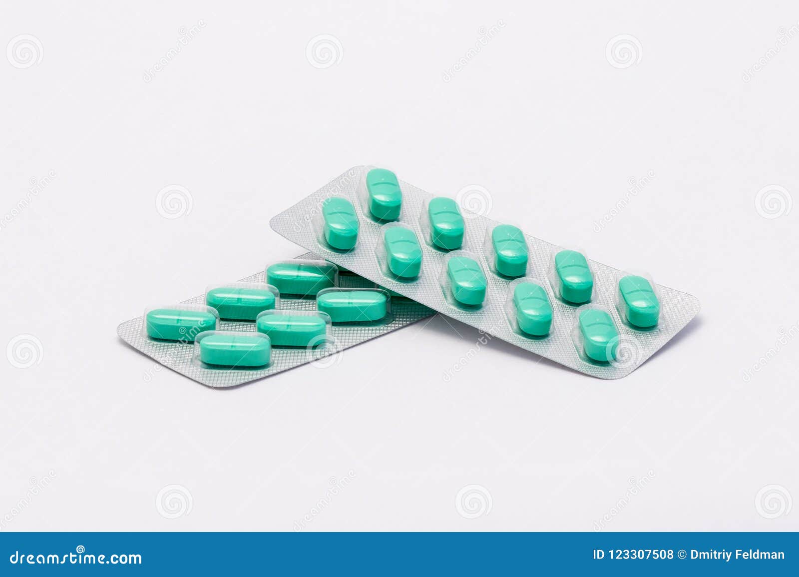 Two Full Sealed Packages with Green Rectangular Pills Lie on a White ...