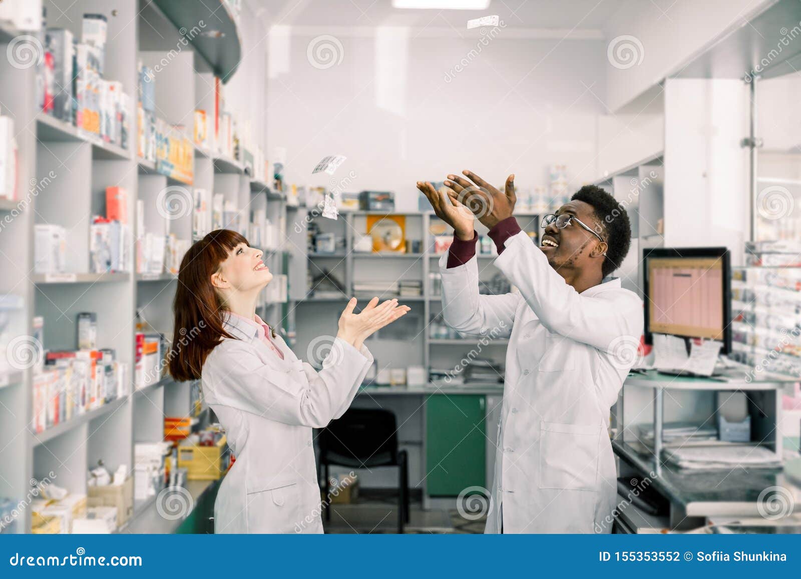 Two Funny Smiling Young Pharmacists Having Fun in Pharmacy, Throw Up ...