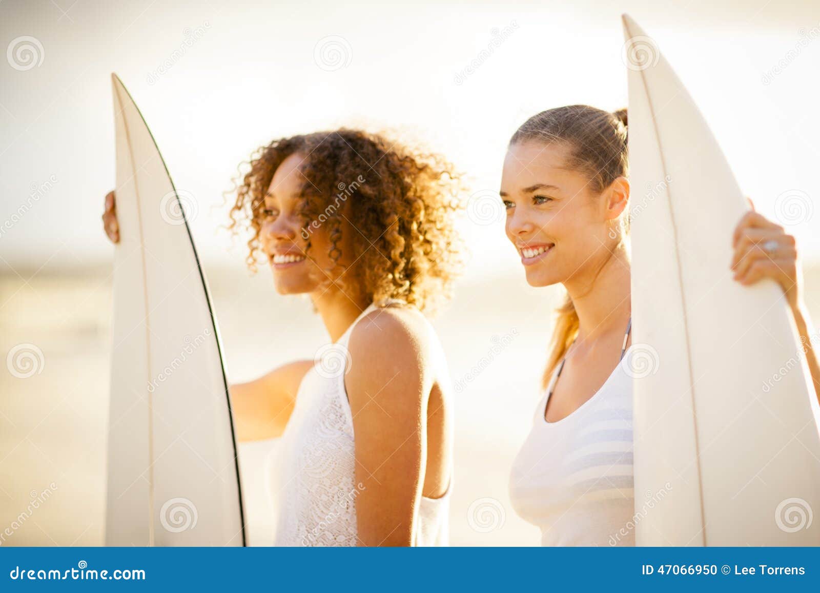 Two girl surfers at sunset stock photo. Image of girls - 47066950