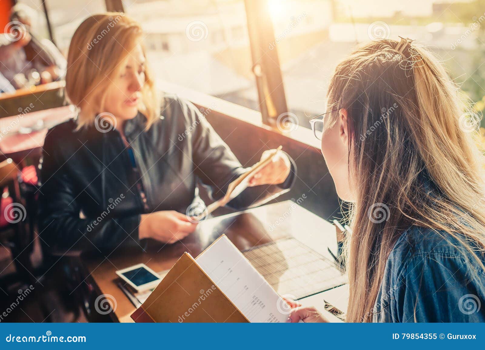 Two Girlfriends in Restaurant Choosing Food in Menu Stock Image - Image ...
