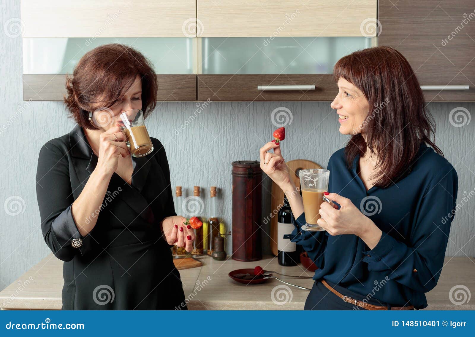 Two Girlfriends Talk and Drink Coffee in the Kitchen Stock Image ...