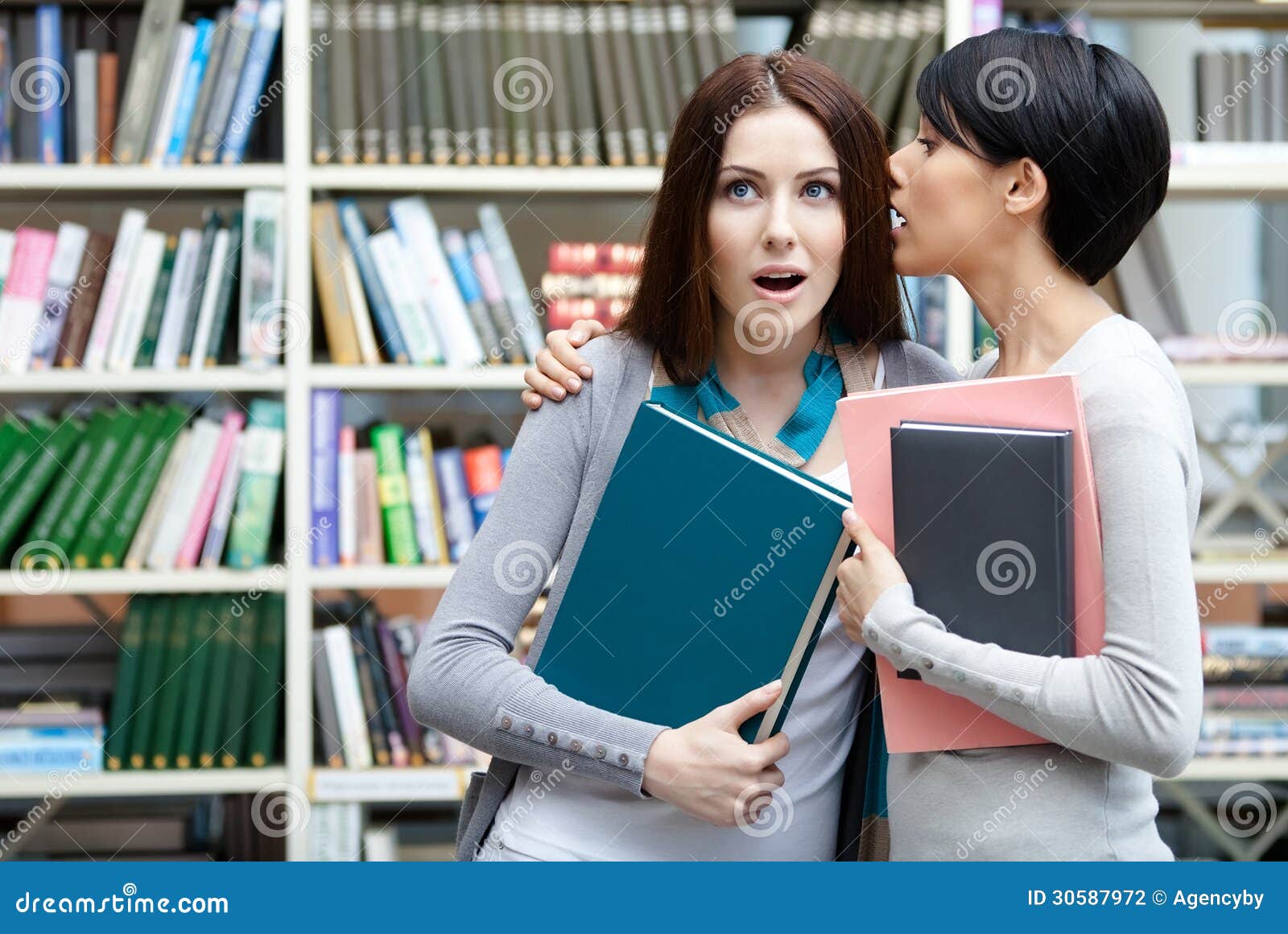Two Girlfriends Whisper at the Library Stock Photo - Image of amazement ...