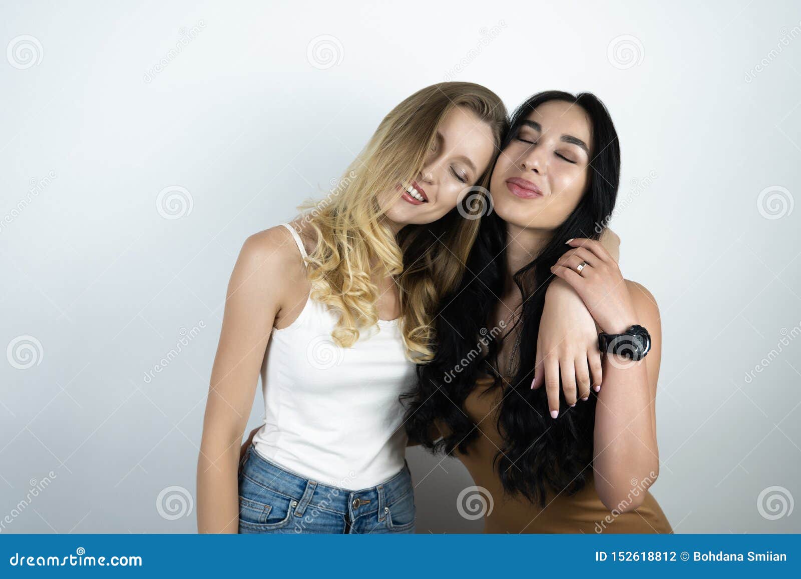 Two Girls Blonde And Brunette Hugging And Smiling White Background