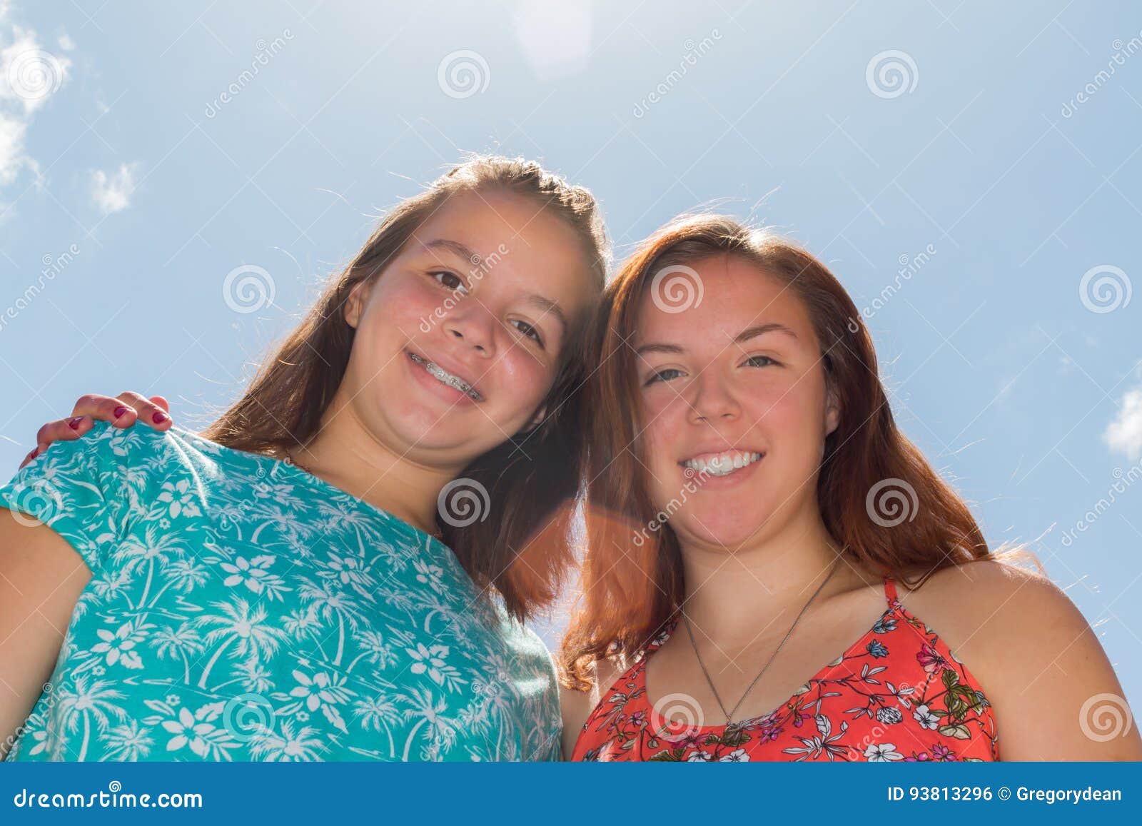 Two Girls with Blue Sky and Sunlight in the Background Stock Photo ...