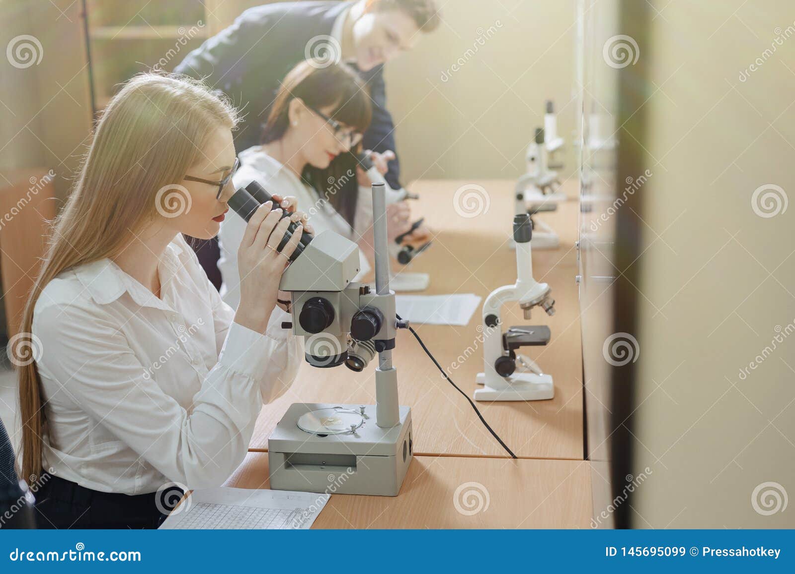 Two Girls and a Boy Work with Microscopes Stock Image - Image of female ...