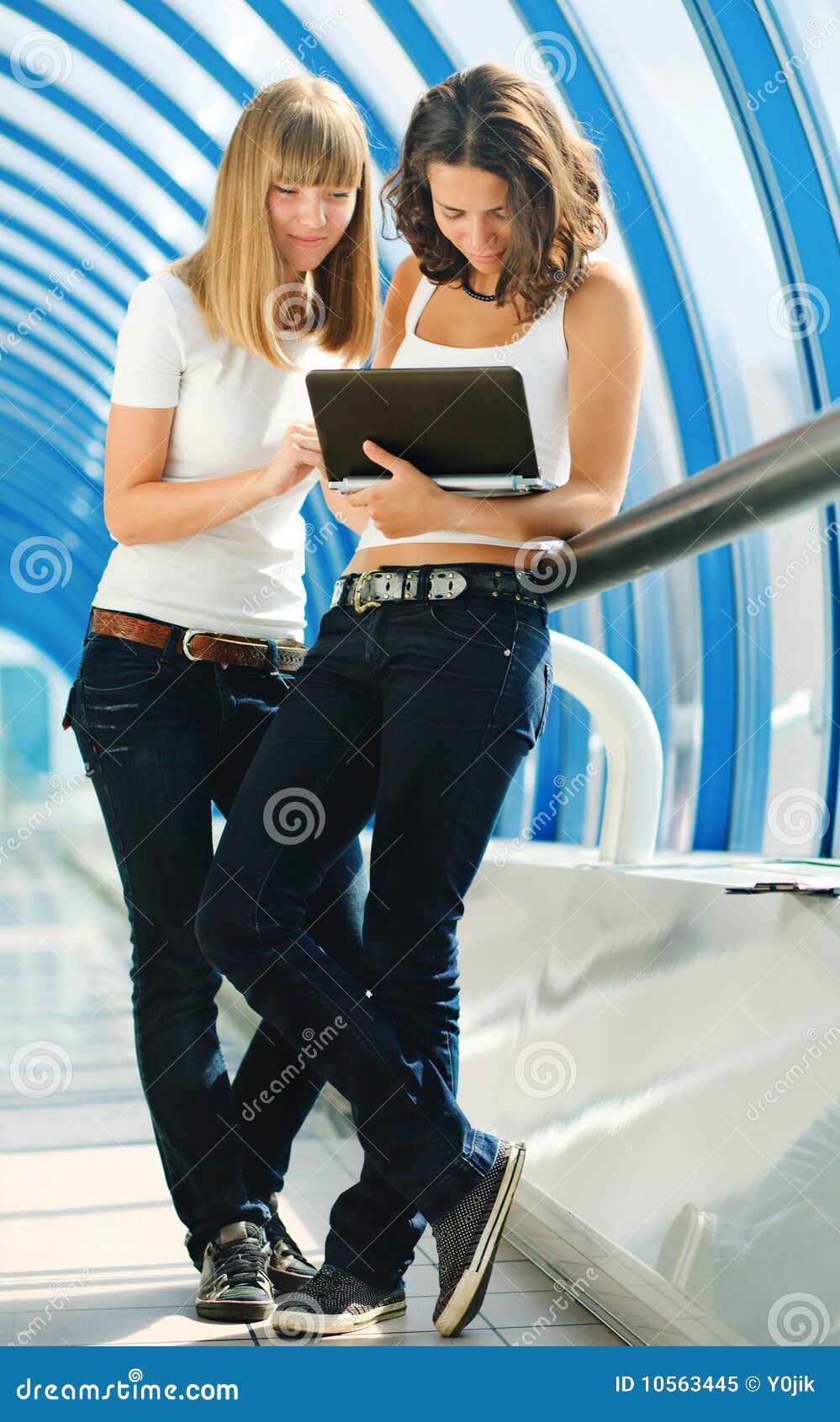 Two girls with a computer stock image. Image of positive - 10563445
