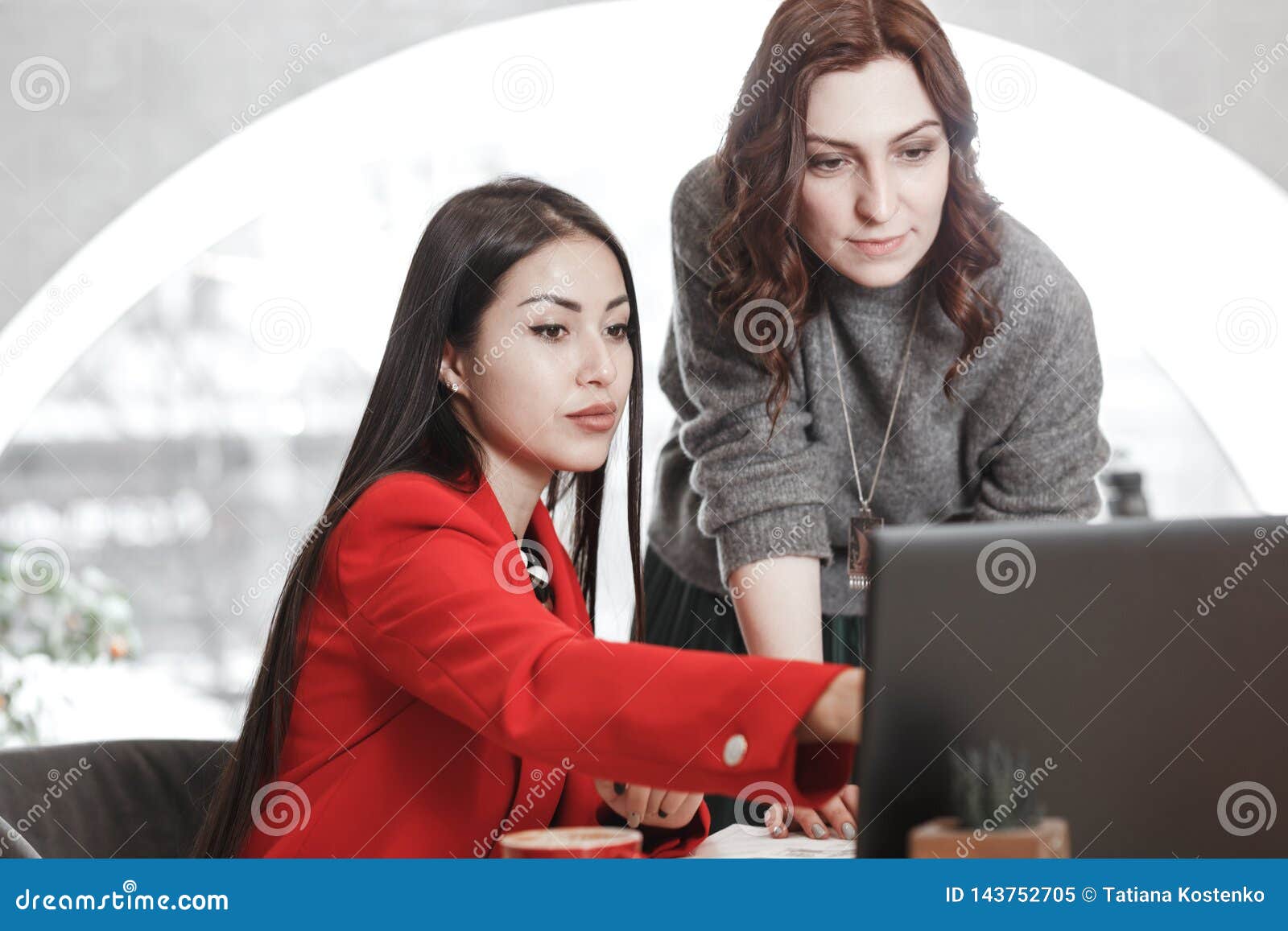 Two Girls Designers are Working with Laptop and Documentation at the ...