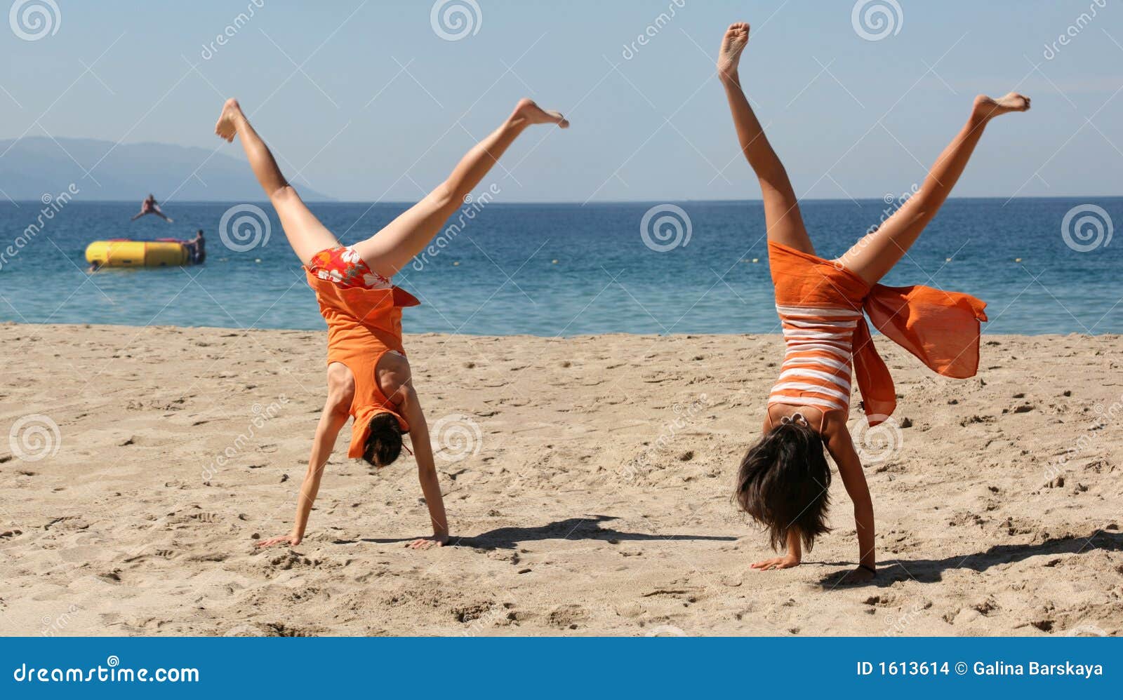 Two girls doing cartwheel stock photo. Image of blue, athlete - 1613614