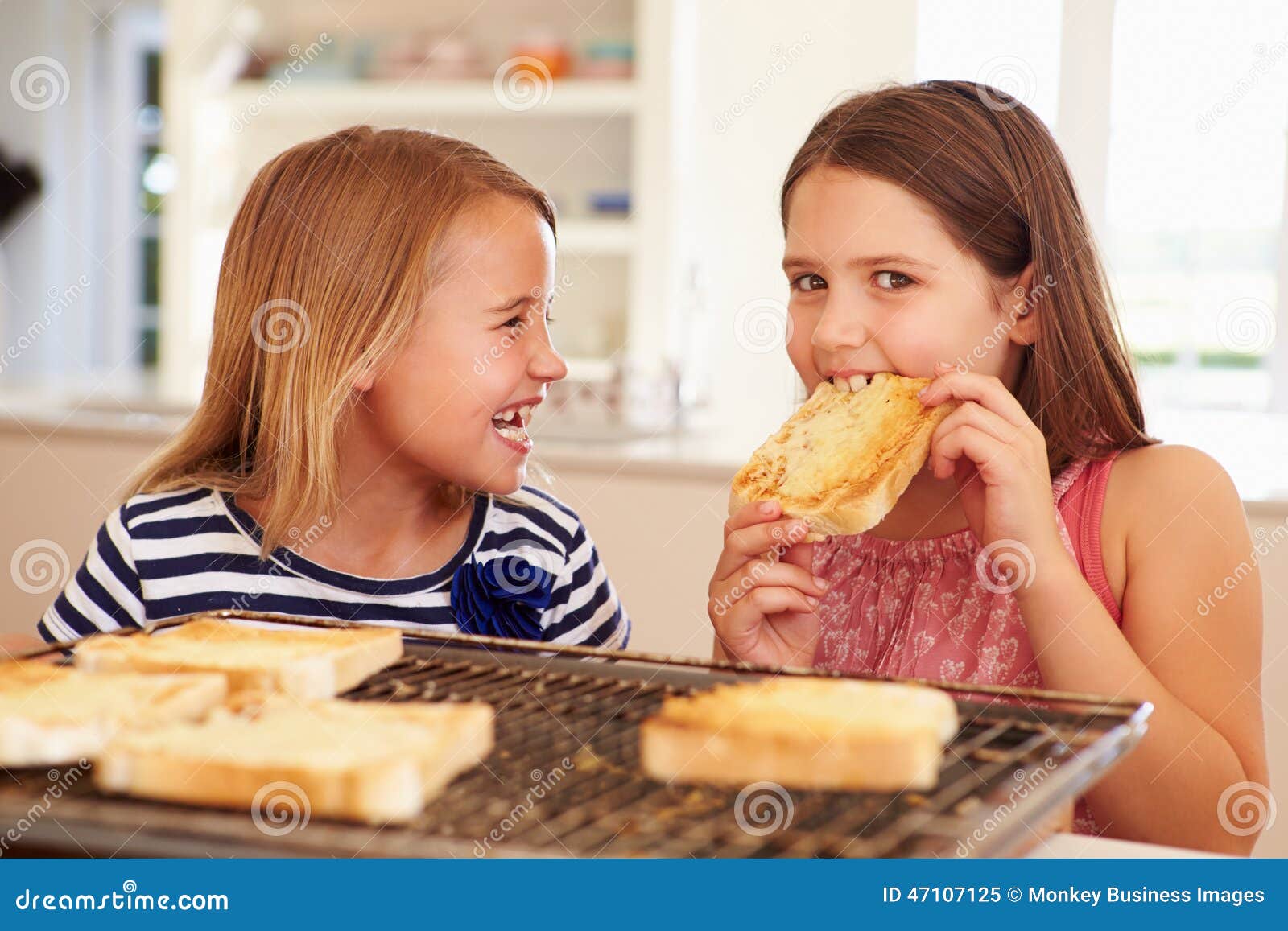 Two Girls Eating Cheese on Toast in Kitchen Stock Image - Image of ...