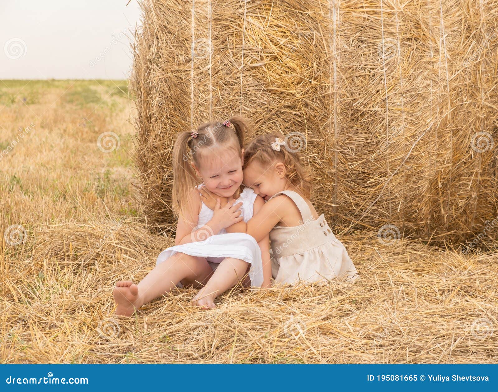 Two Girls Hugging Sitting on the Hay. Stock Image - Image of light ...