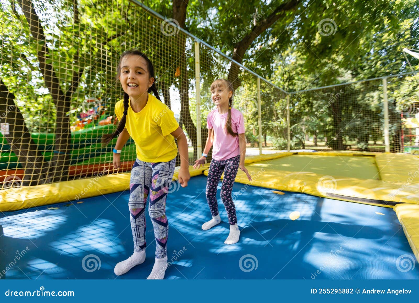 Two Girls Jumping on a Trampoline on a Summer Day. Stock Photo - Image ...