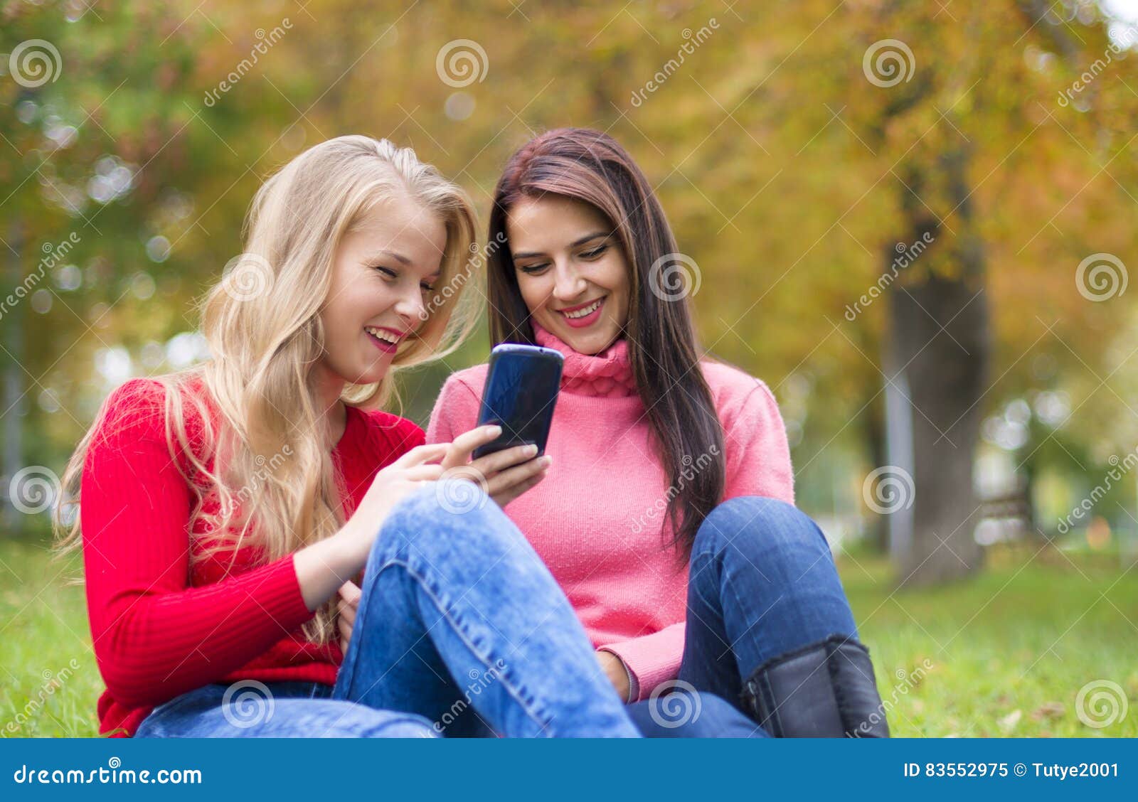 Two Girls in Park with a Mobile Phone in Autumn Stock Image - Image of ...