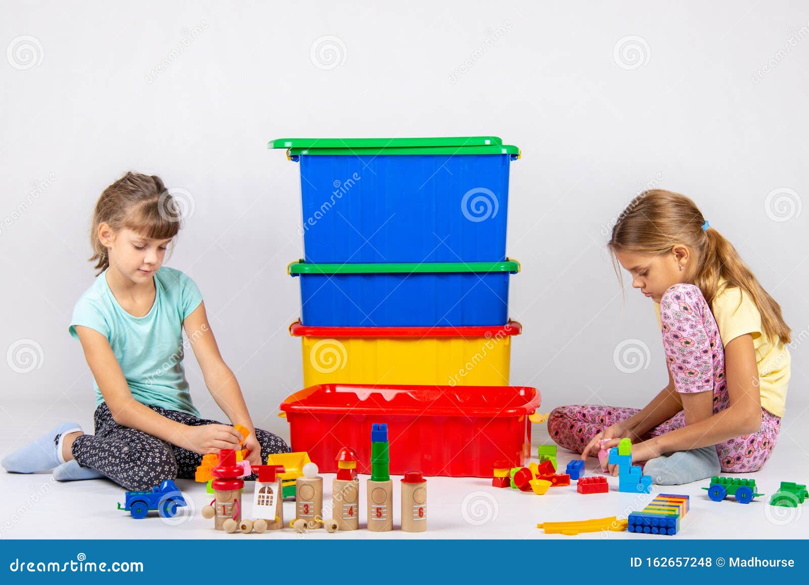 Two Girls Play Toys, in the Middle are Boxes with Toys Stock Photo ...