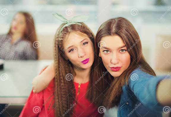 Two Girls Pouting While Taking A Selfie Photo On Mobile Phone Stock