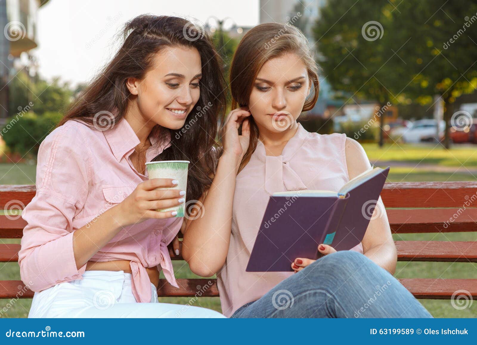 Two girls reading a book stock image. Image of break - 63199589