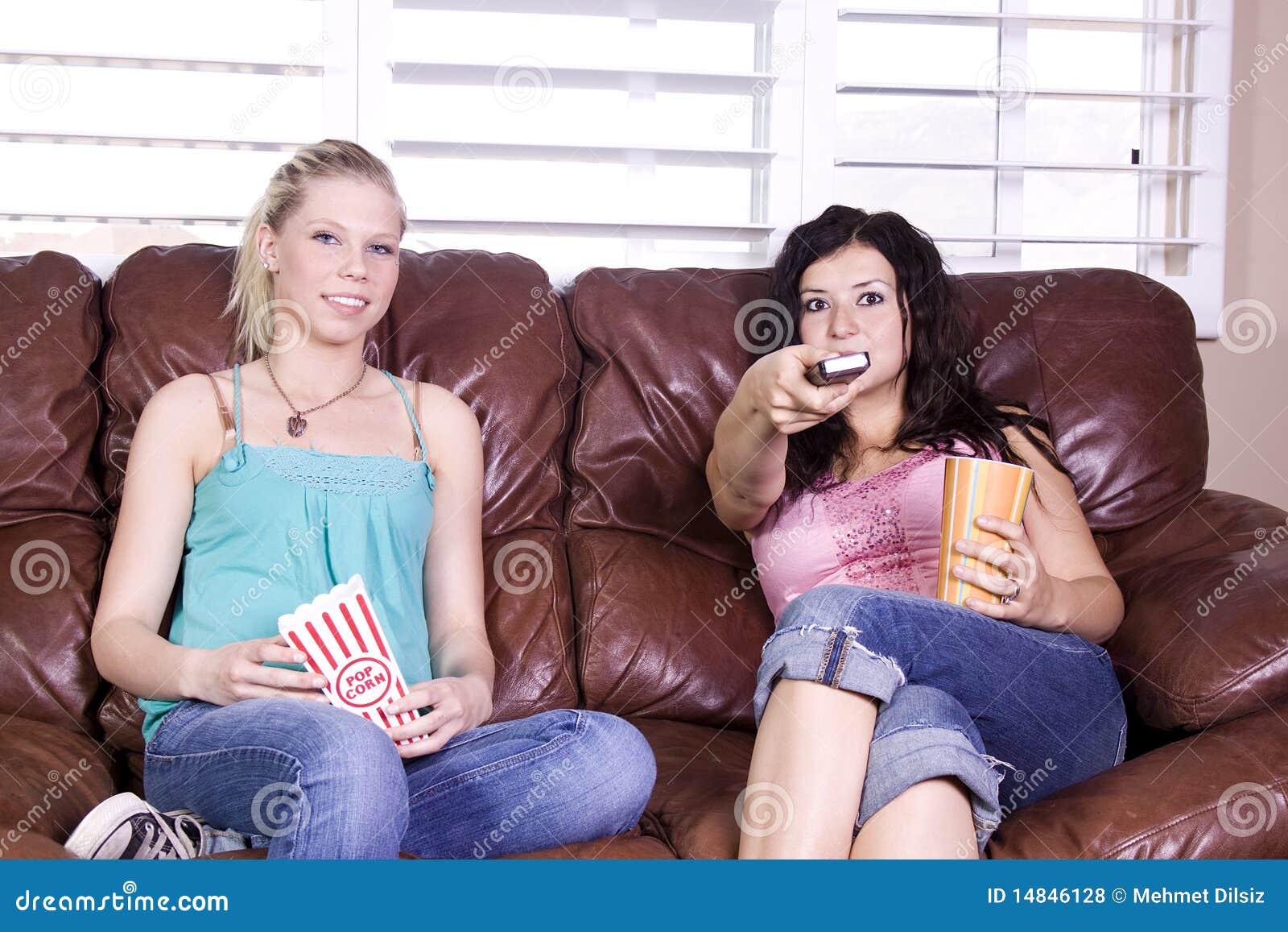 Two Girls Sitting On The Sofa Watching A Movie Stock Photo - Image of ...