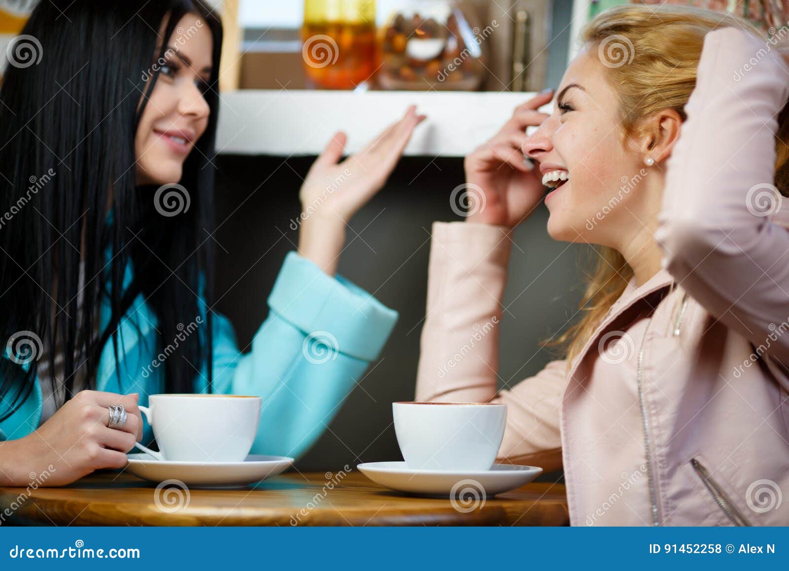 Two girls talking in cafe stock photo. Image of city - 91452258