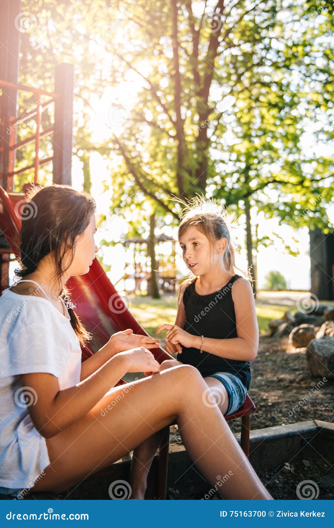 Two Girls Talking on a Playground in Summer Stock Photo - Image of ...