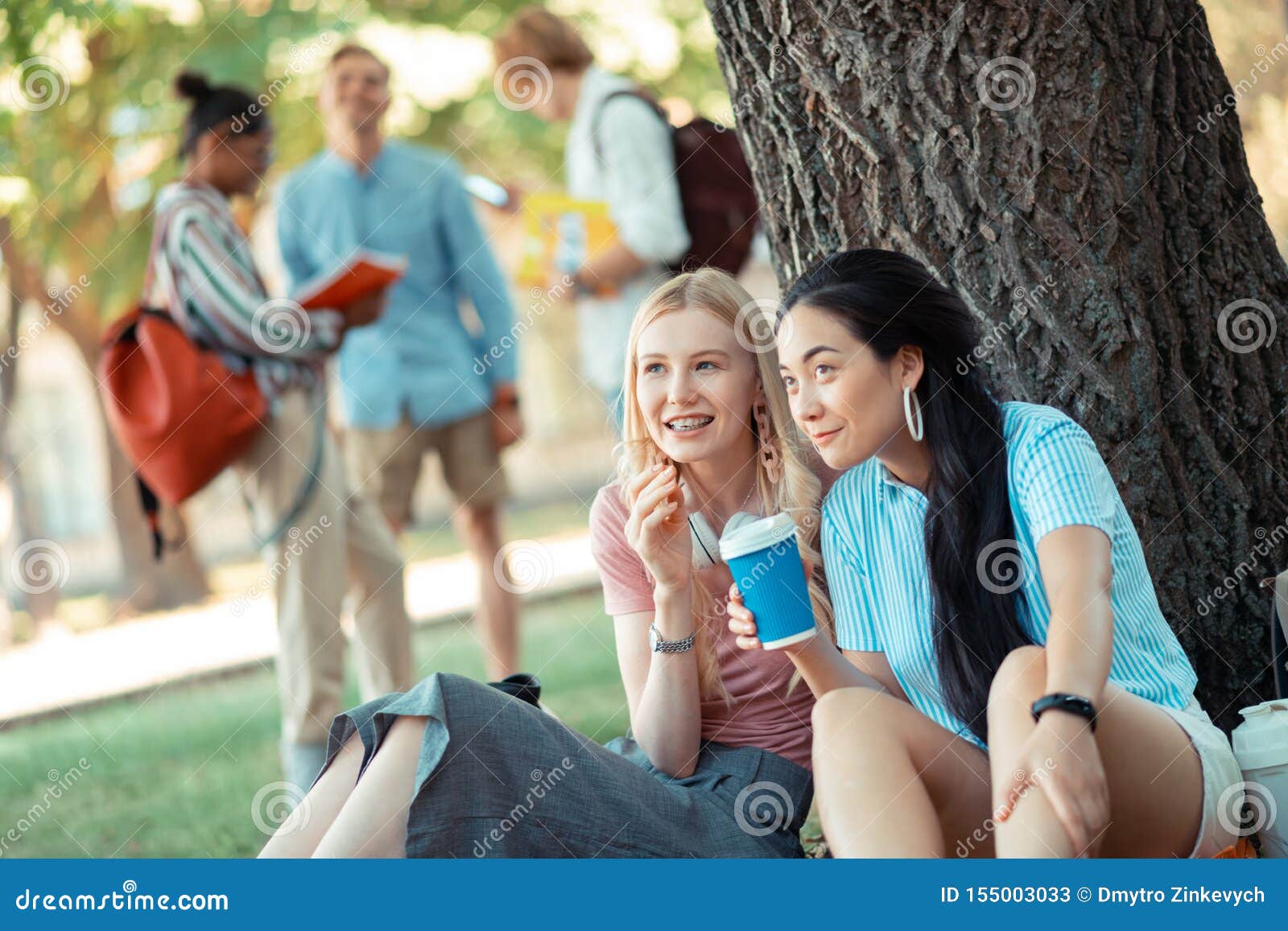 Two Girls Talking about Their Groupmates in the Front. Stock Image ...