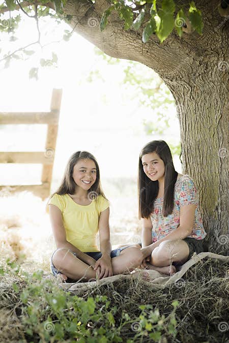 Two Girls Under a Tree stock image. Image of friendship - 11124241