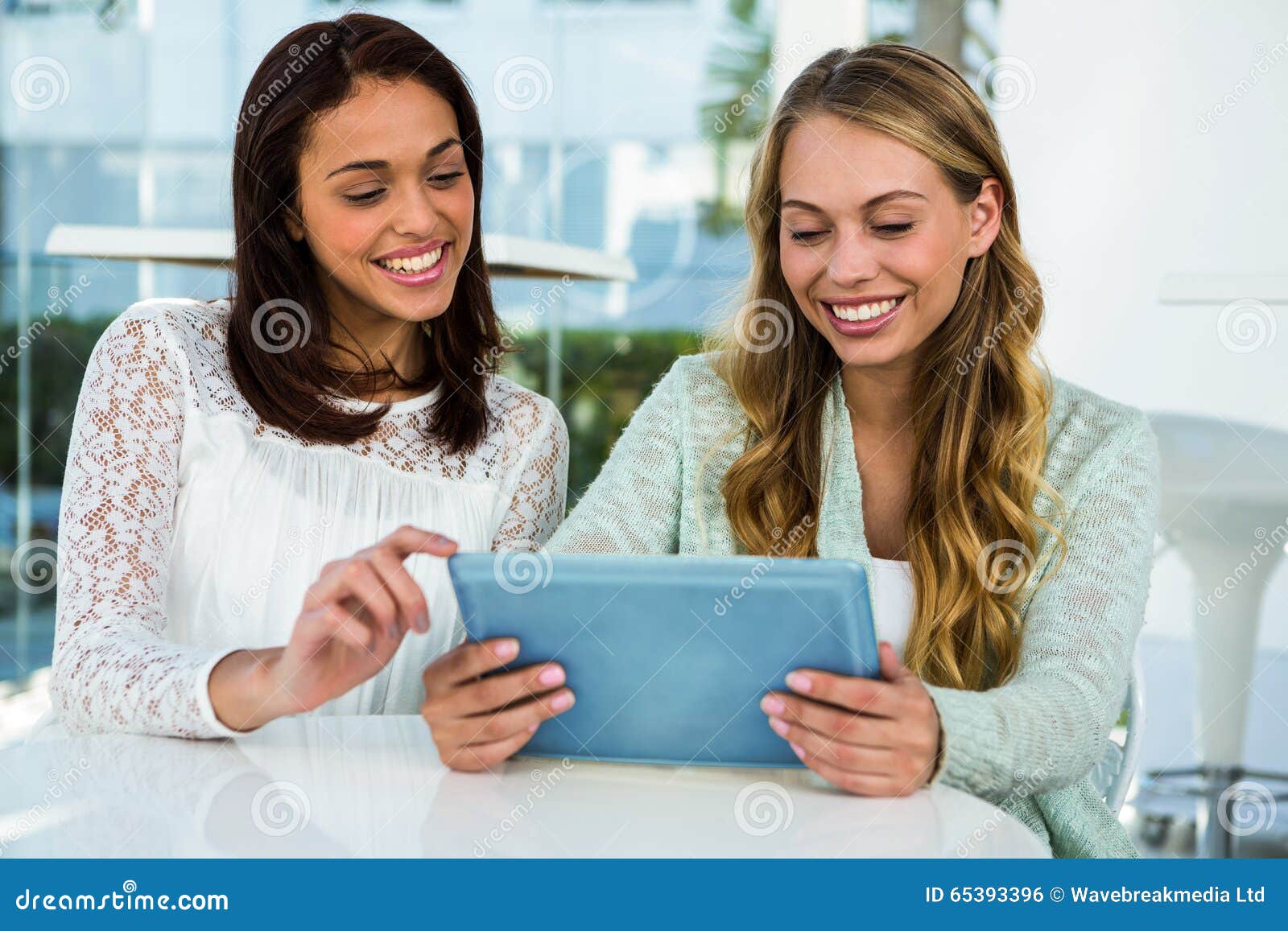 Two girls use a tablet stock photo. Image of adult, blonde - 65393396