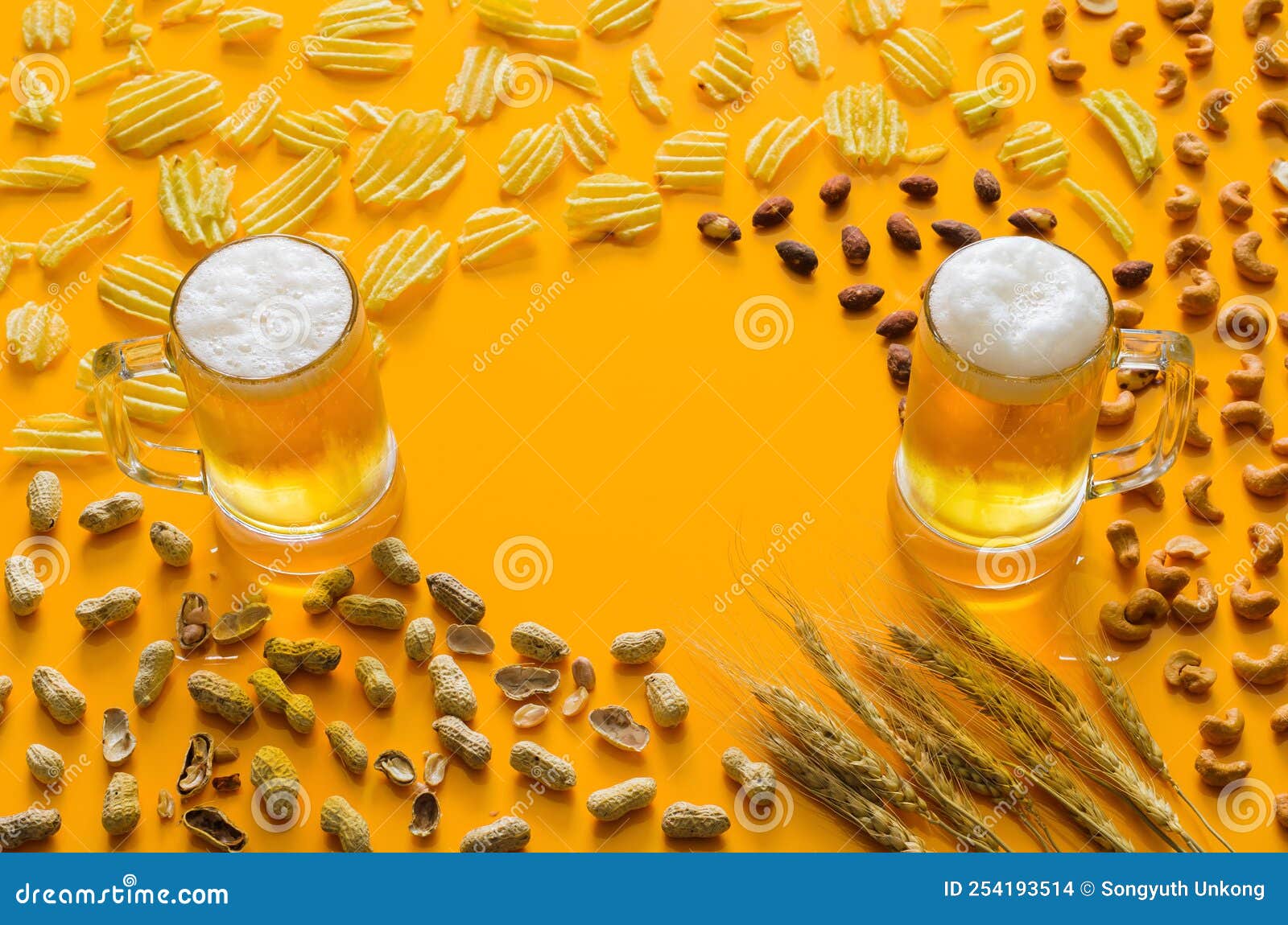Two Glasses of Beer with Chips and Nuts on Yellow Background Stock ...