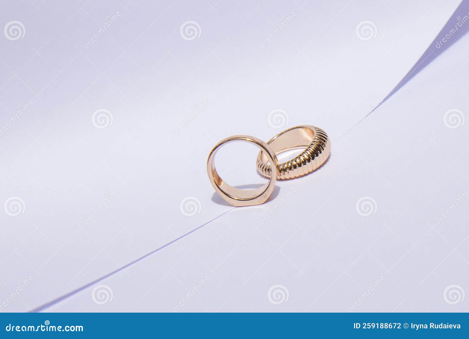 Two Gold Wedding Rings on White Background with Contrasting Shadows ...