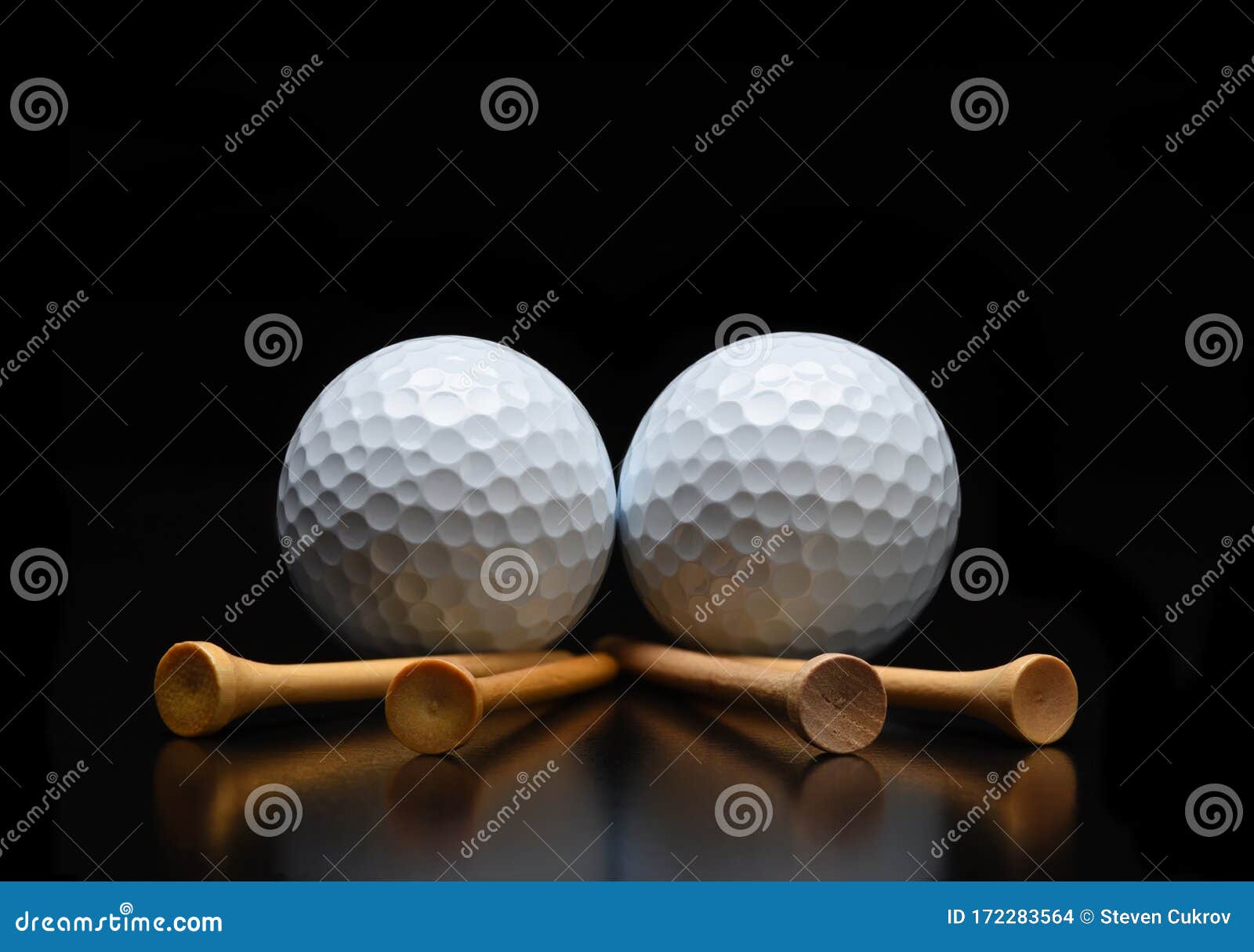 Two Golf Balls with Tees Laying on a Black Reflective Surface. Low ...
