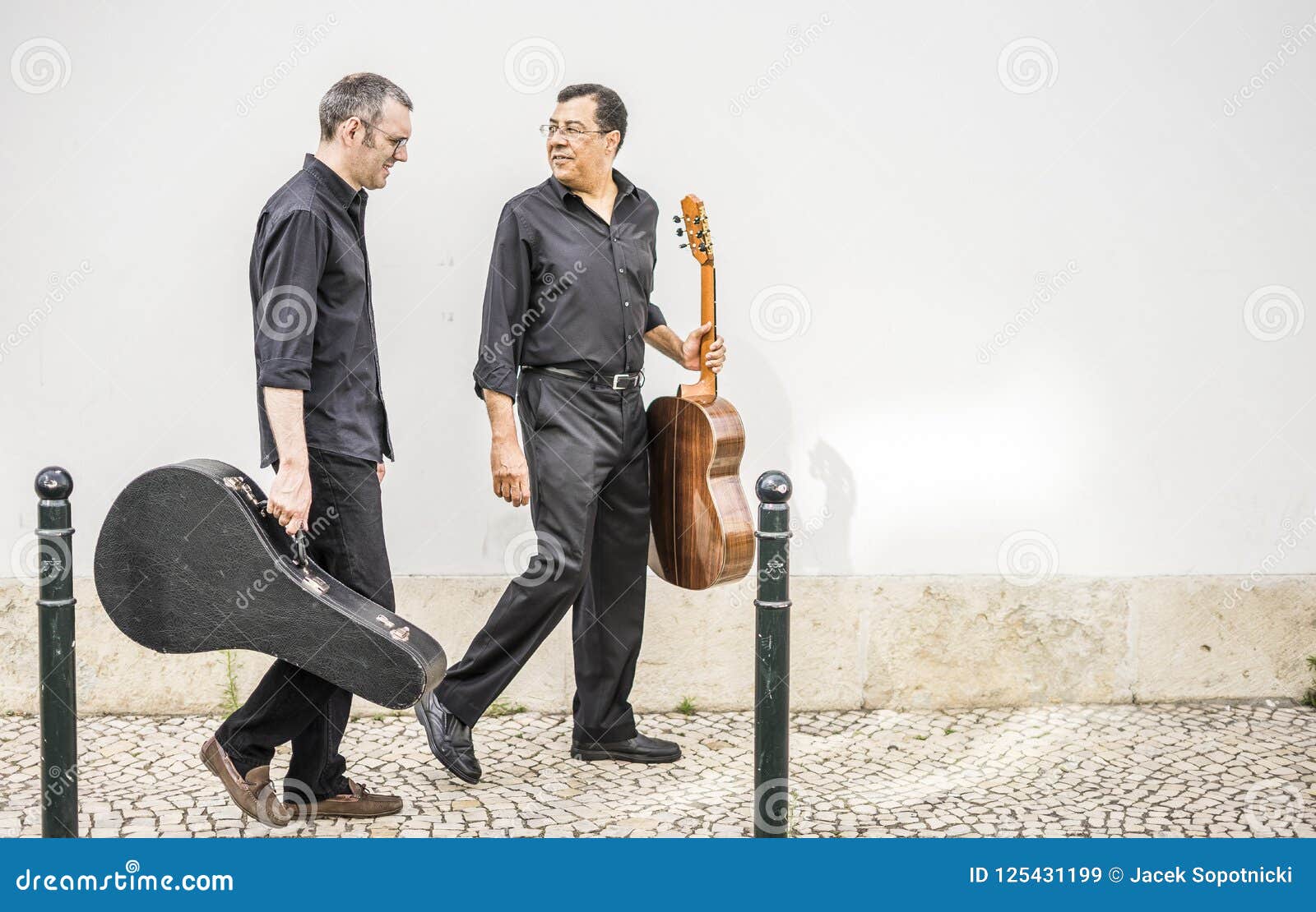 Two Guitarists Walking with Their Instruments on the Street Stock Image ...