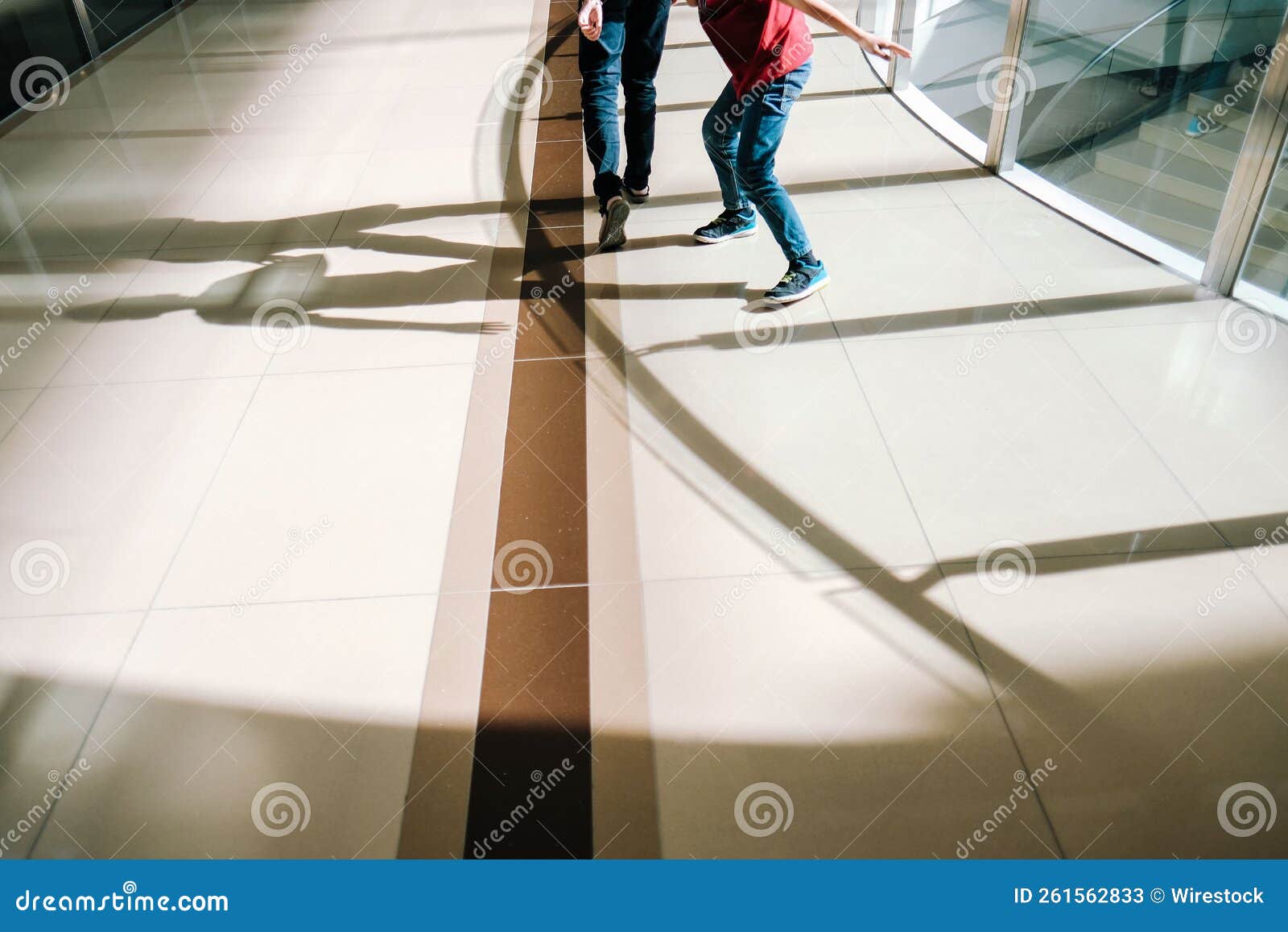 Two Guys Running in a Hallway of a Building in Front of the Windows on ...