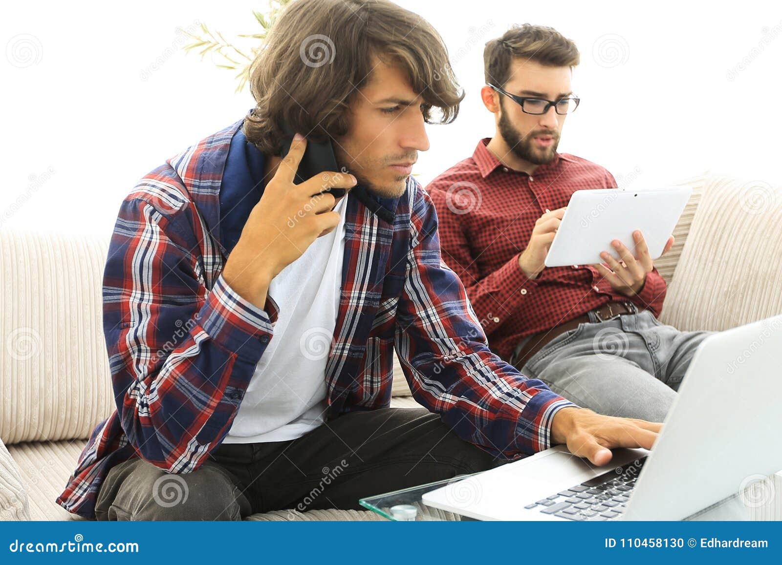 Two Guys Sitting on the Couch, Talking on a Mobile Phone and Chatting ...