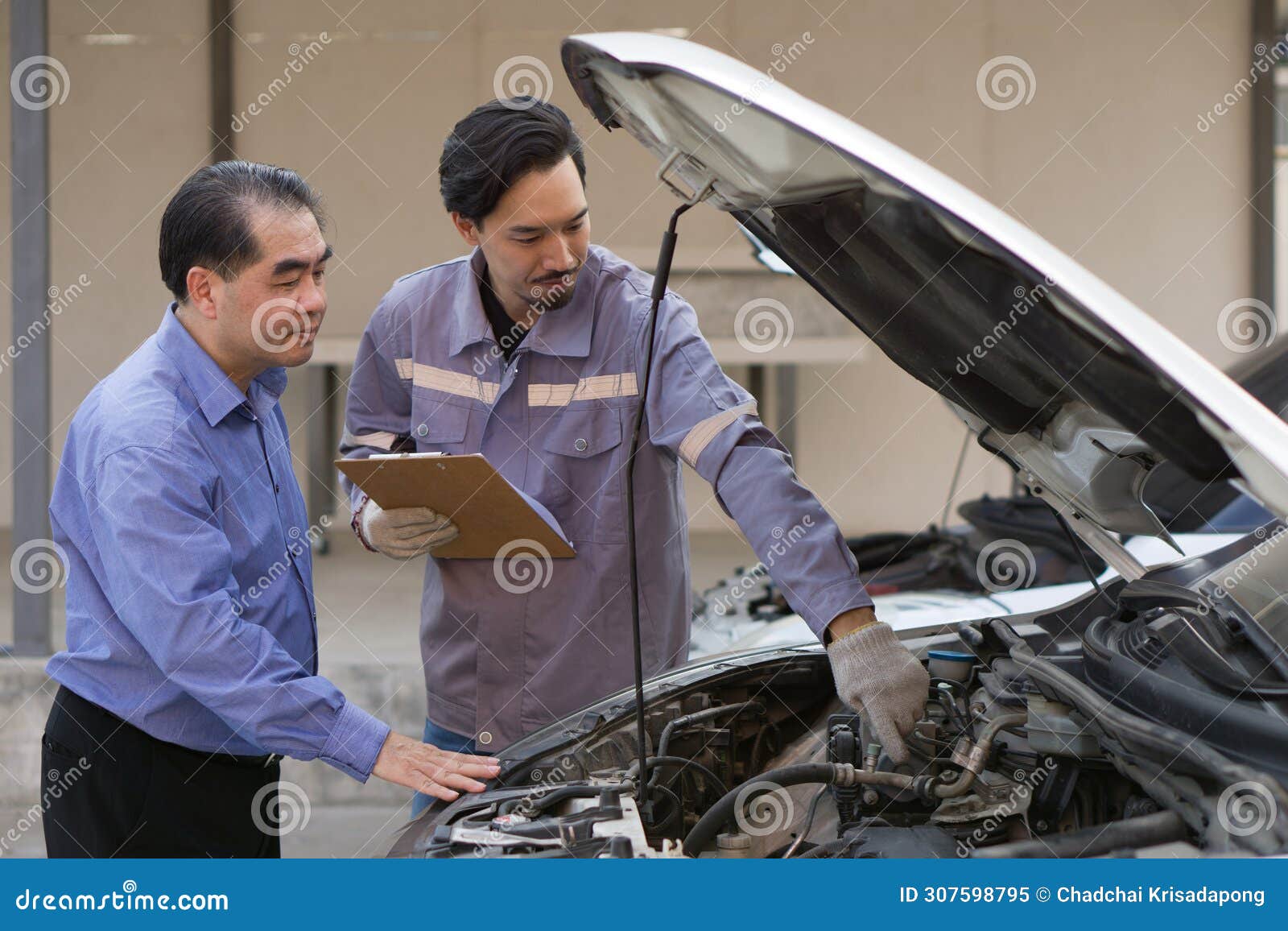 Two Guys are Standing by a Car with the Hood Open, Staring at the ...