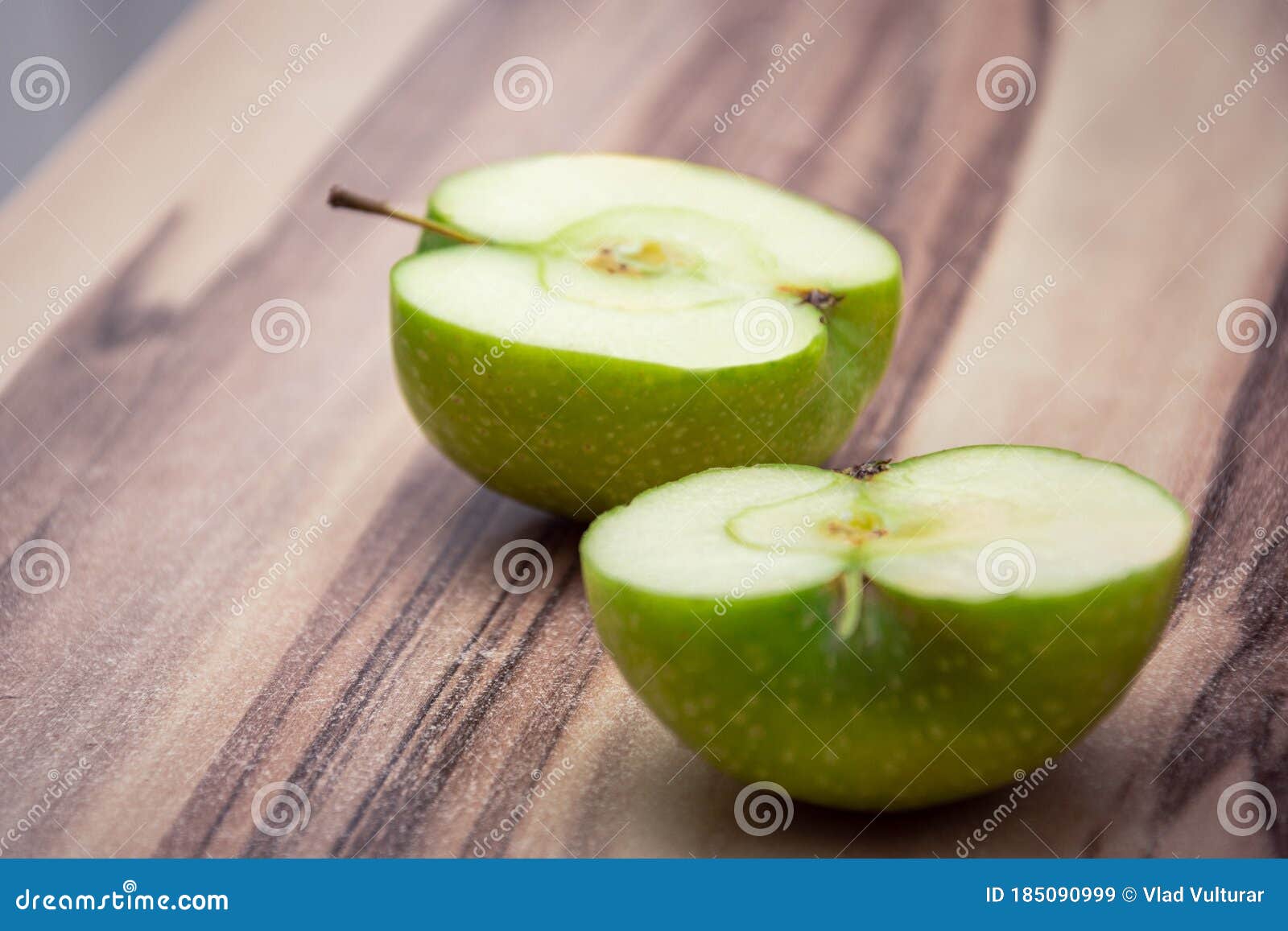 Two Half of a Green Round Apple Laying on a Table Stock Image - Image ...