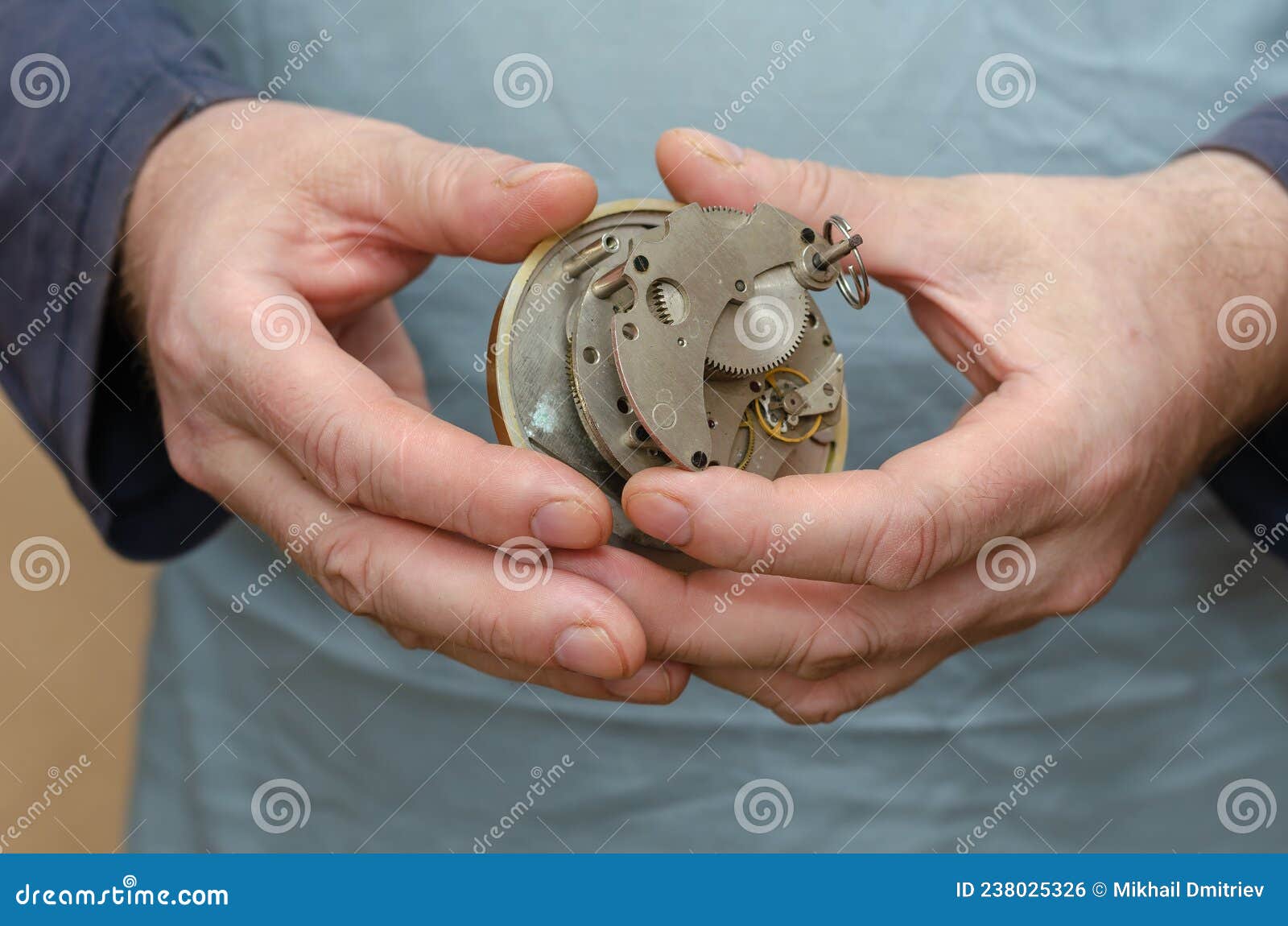 Two Hands Hold the Mechanism of a Table Clock. a Man is Holding Stock ...