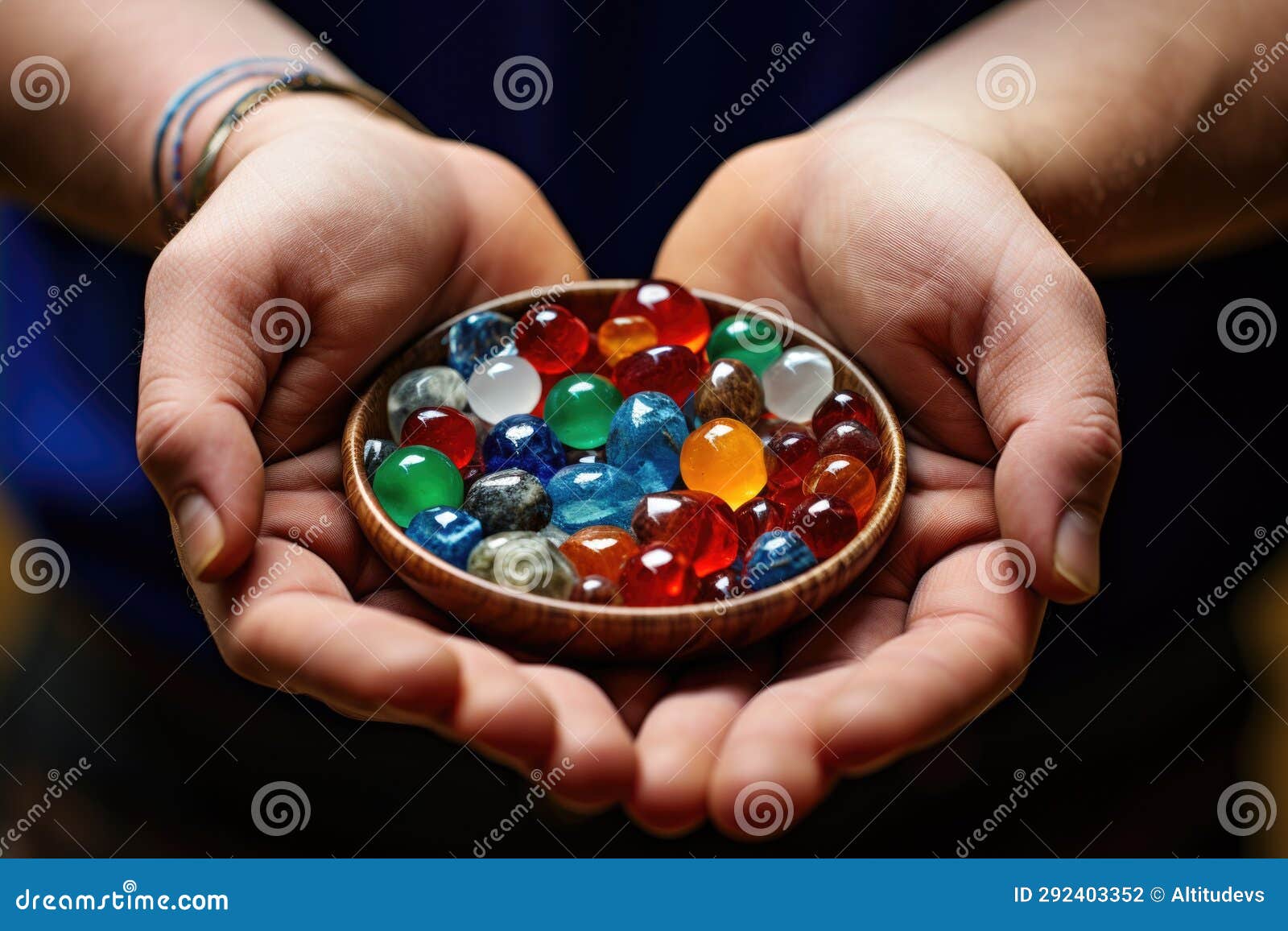 Two Hands Holding Different Colored Marbles Near a Bowl Stock Photo ...