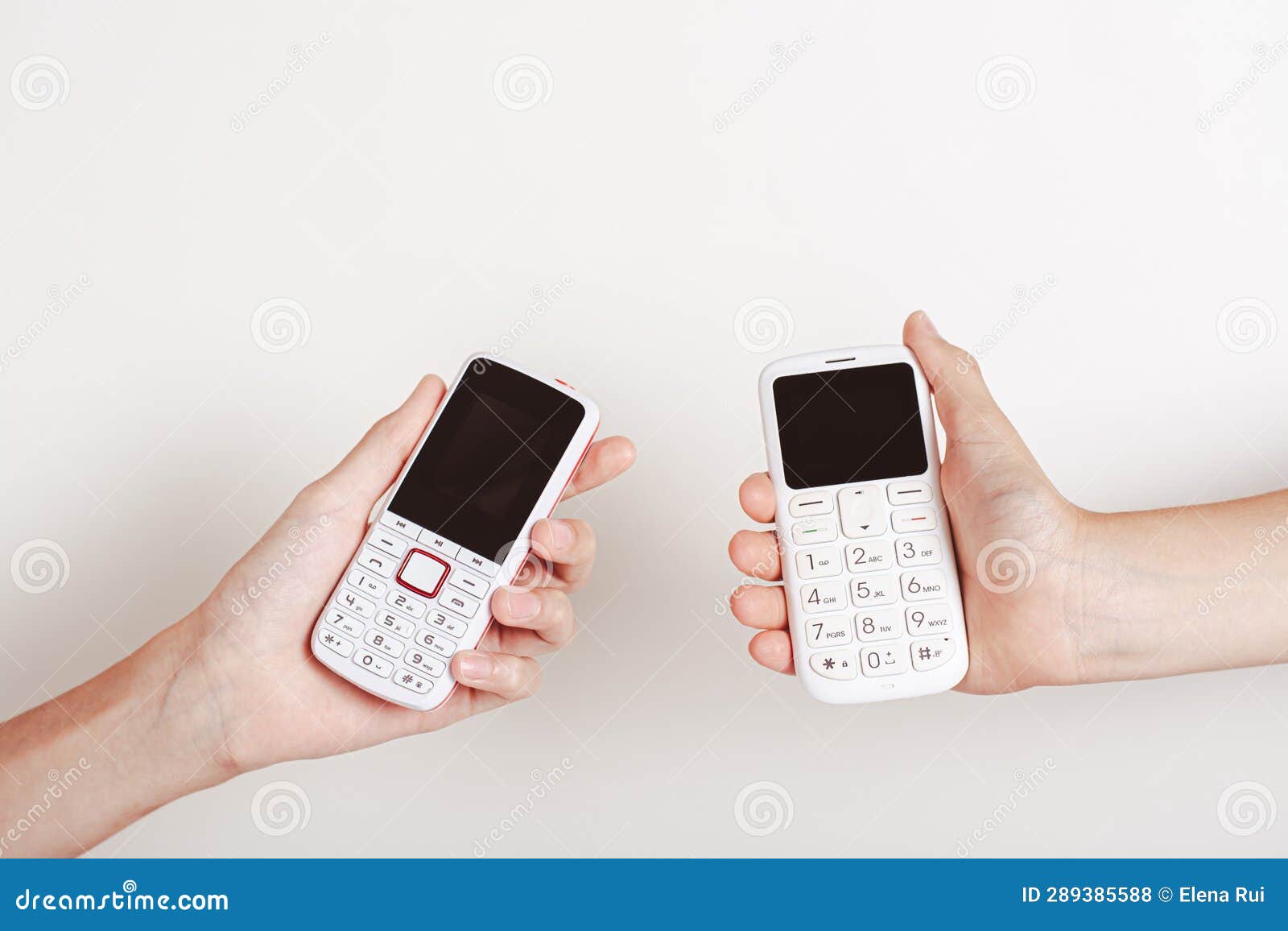 Two Hands are Holding Push-button Phones on a Light Background Stock ...