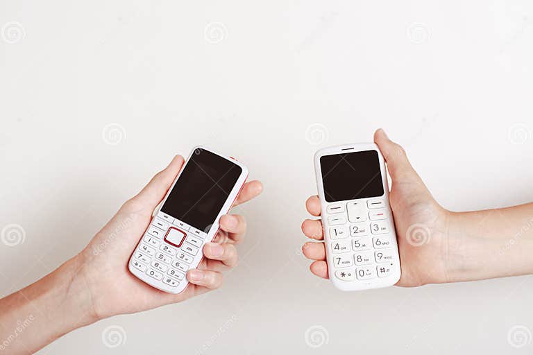 Two Hands are Holding Push-button Phones on a Light Background Stock ...