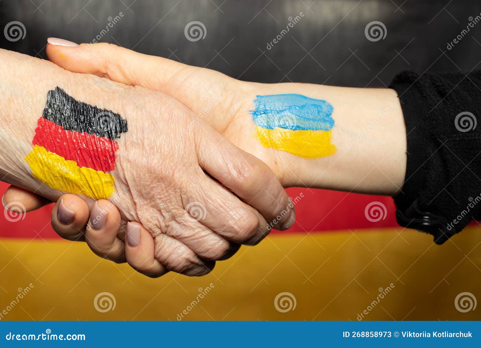Two Hands One with a Drawn Flag of Germany and the Second with a Drawn ...