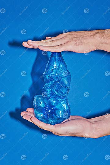 Two Hands Squeezing Plastic Bottle on Blue Background. Zero Waste ...