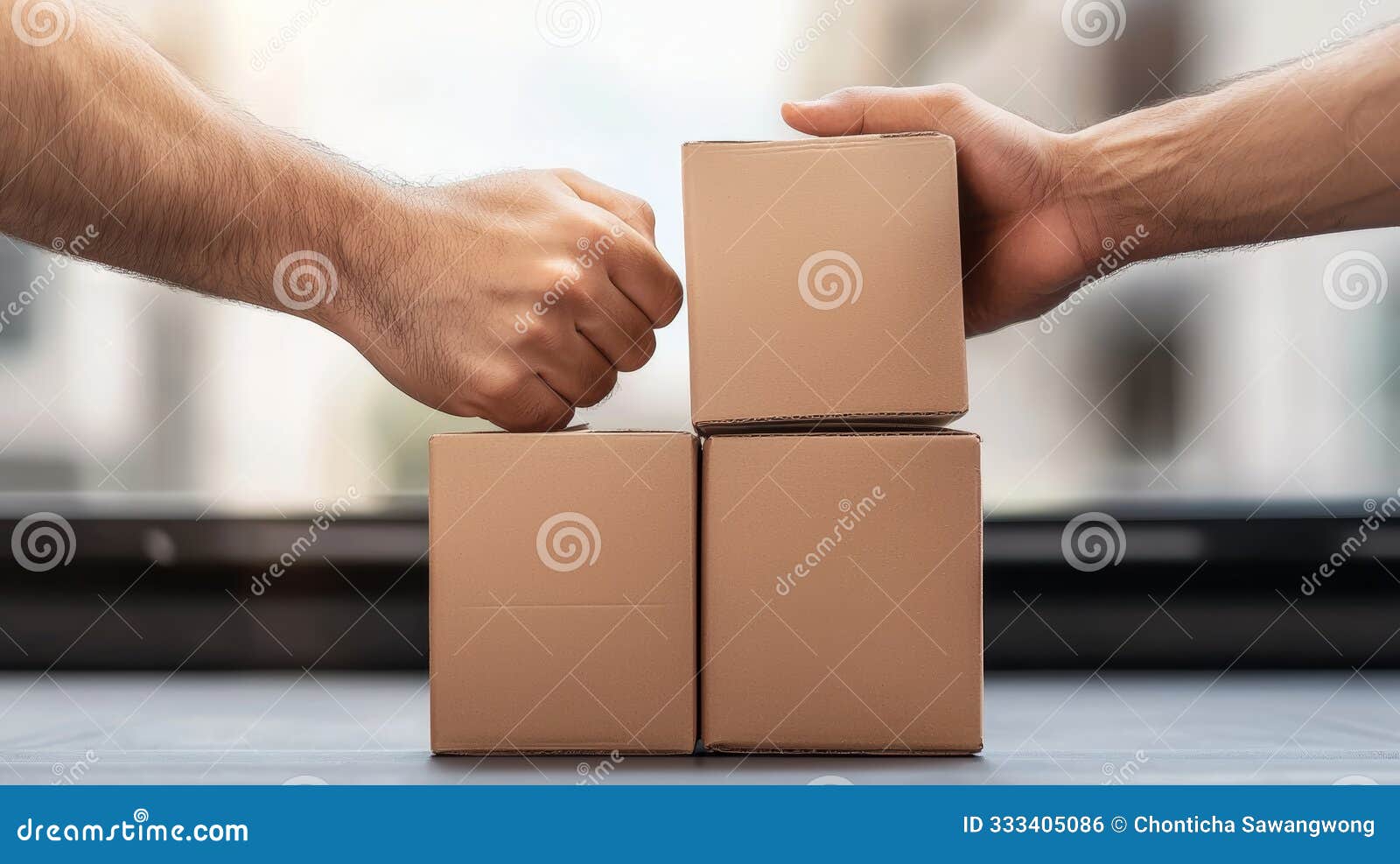 Two Hands Stacking Cardboard Boxes, Symbolizing Teamwork and ...