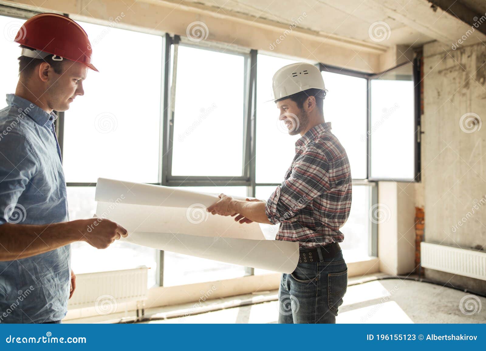 Two Handsome Builders are Unfolding a Paper Stock Image - Image of ...