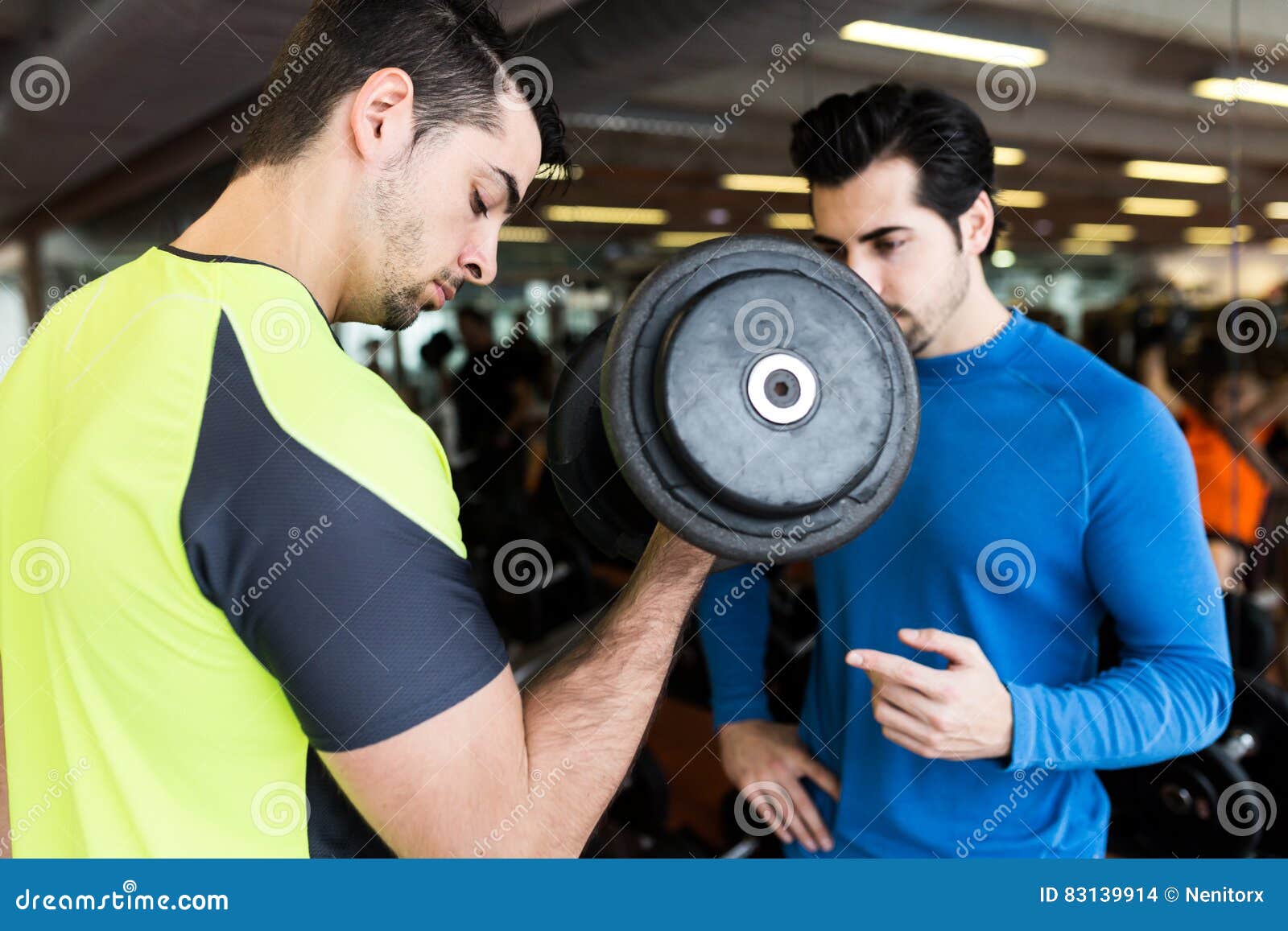 Two Handsome Young Men Doing Muscular Exercise in Gym. Stock Photo ...
