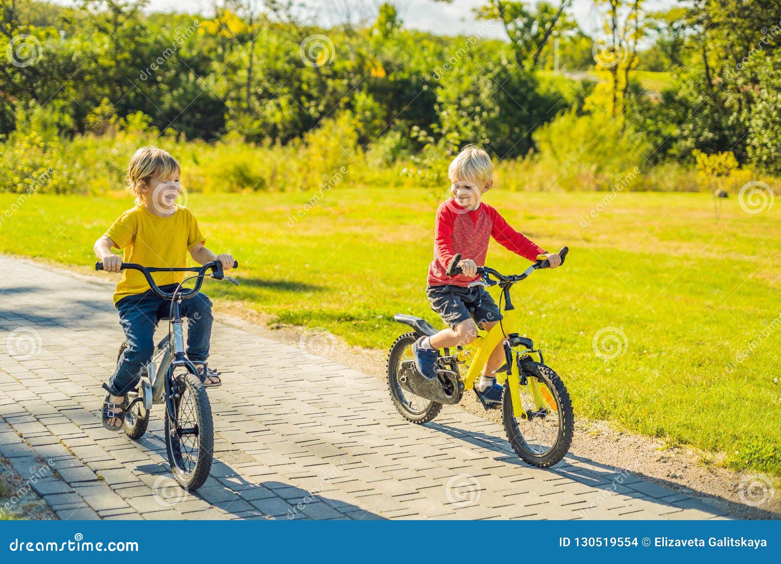 Two Happy Boys Cycling in the Park Stock Photo - Image of action ...