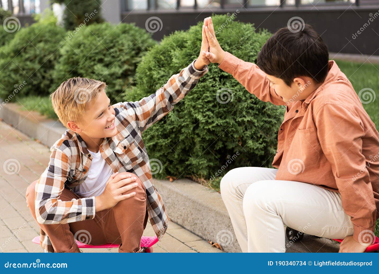 Two Happy Brothers Giving High Five while Sitting Stock Photo - Image ...