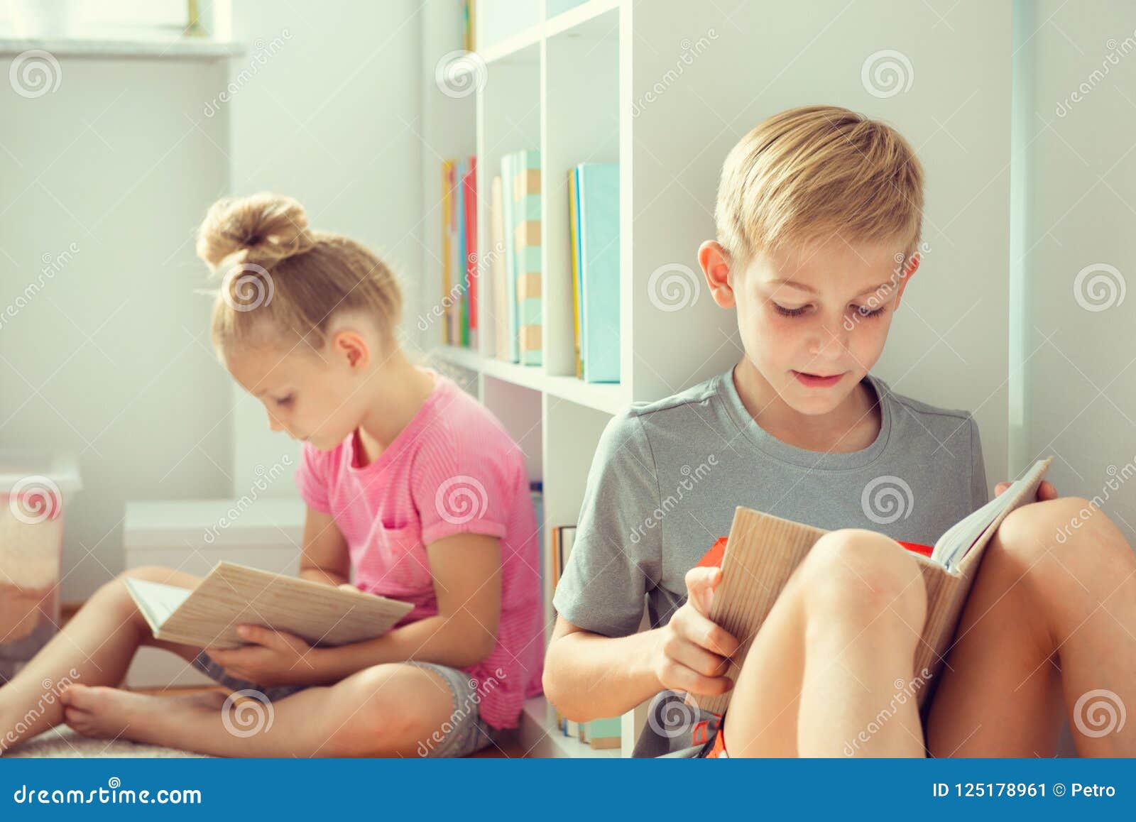 Happy Children Reading Books on the Floor at the School Library Stock ...
