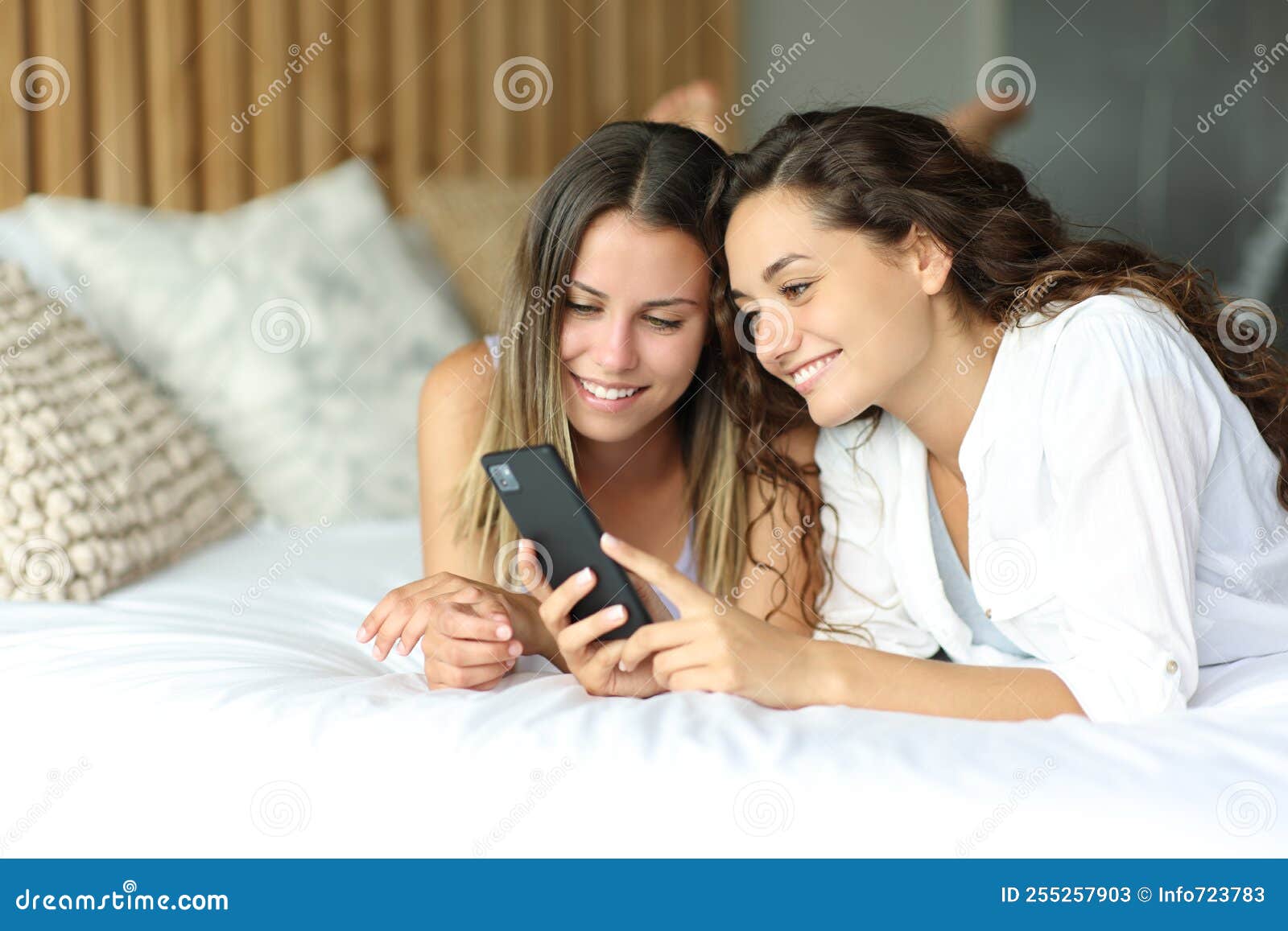 Two Friends Checking Smartphone Lying on a Bed Stock Image - Image of ...