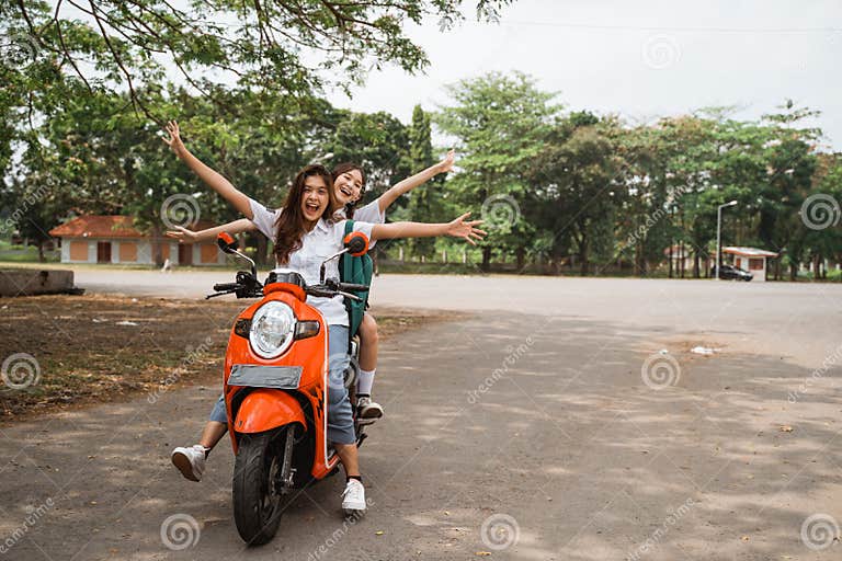 Two Happy High School Girls Riding Motorbikes Waving Hands Stock Photo ... Two Happy High School Girls Riding Motorbikes Waving Hands Stock Photo ...
